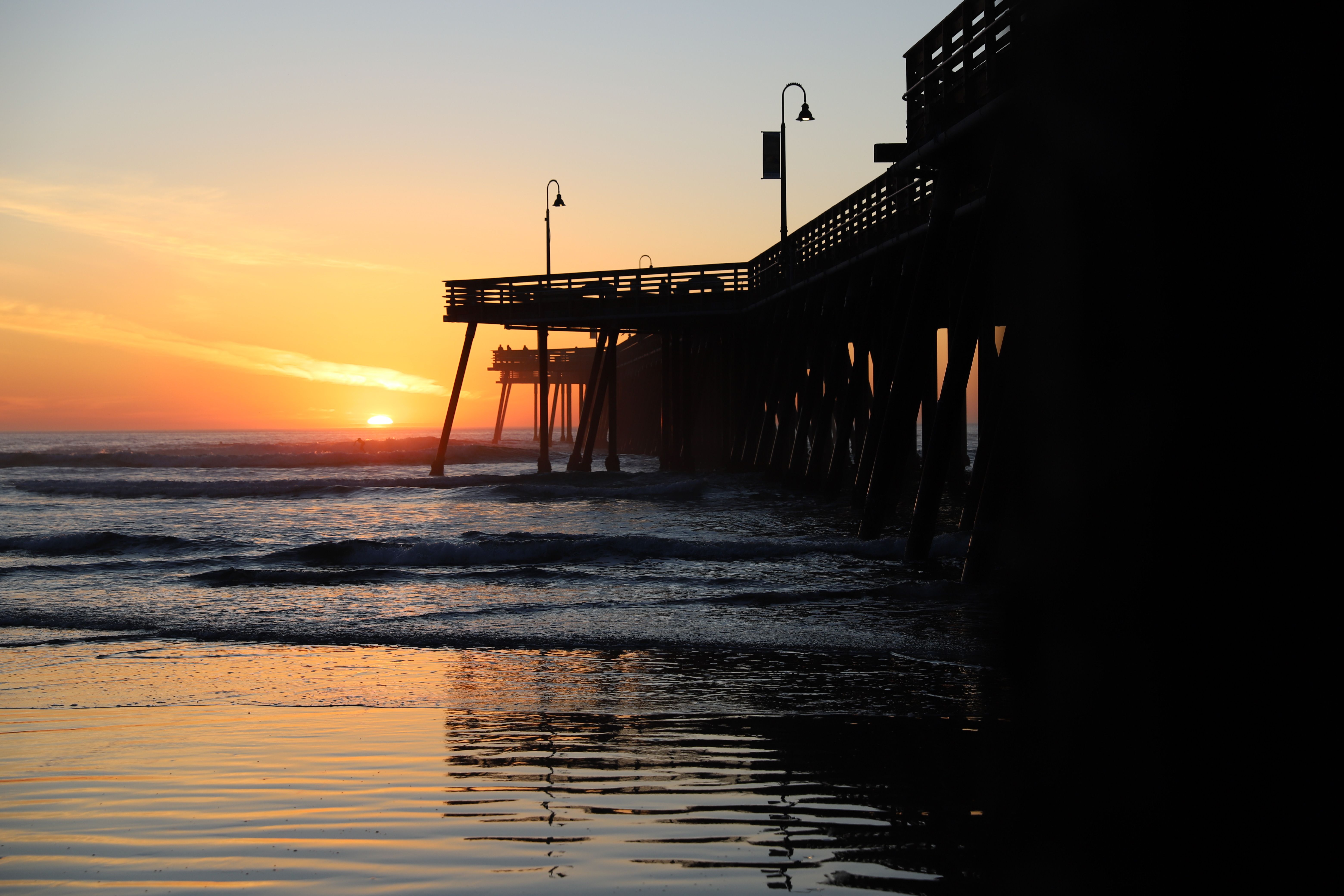 Sunset Over Ocean Pier with Silhouetted Structure · Free Stock Photo