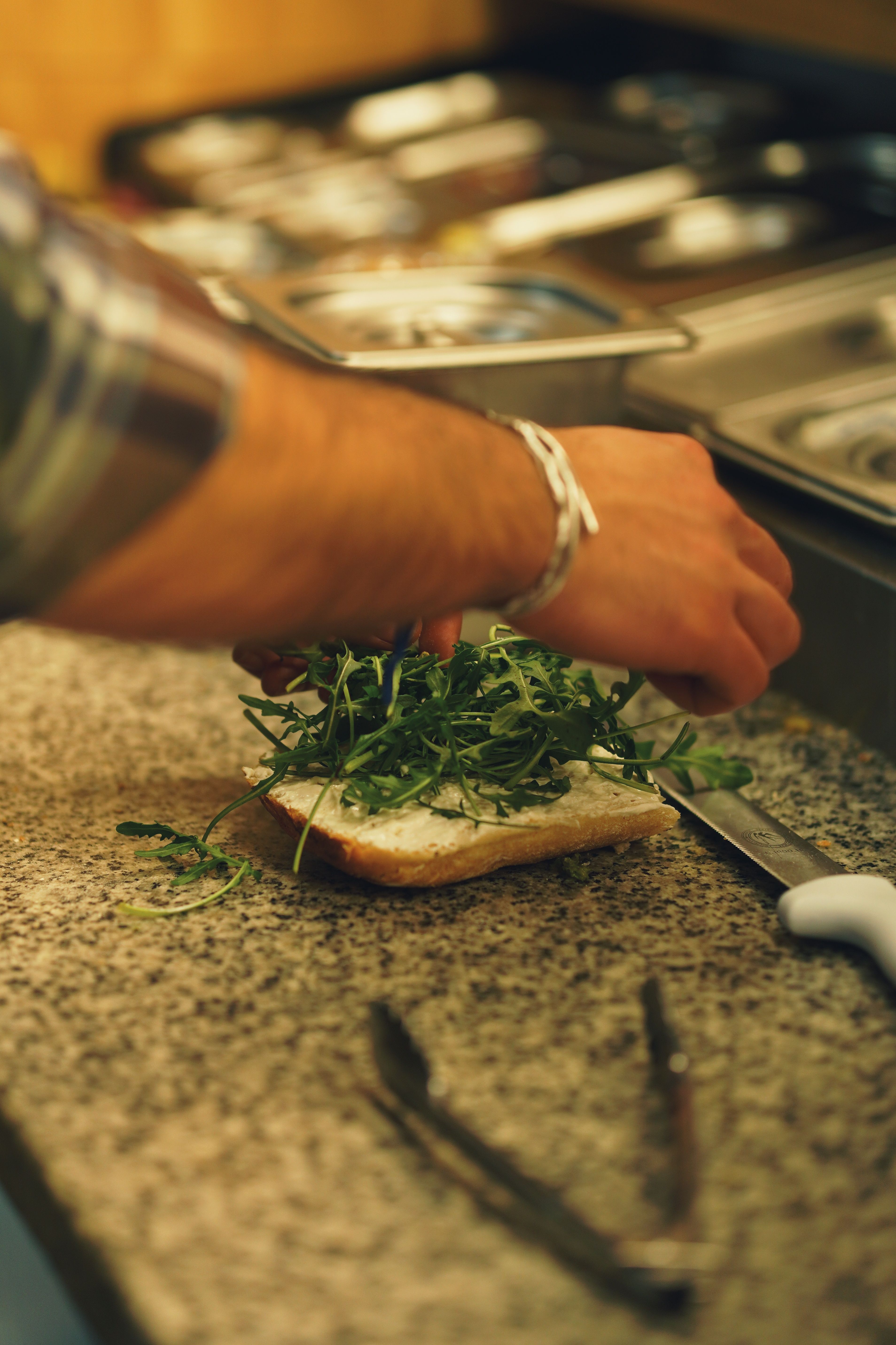 Man Preparing a Fresh Arugula Sandwich · Free Stock Photo