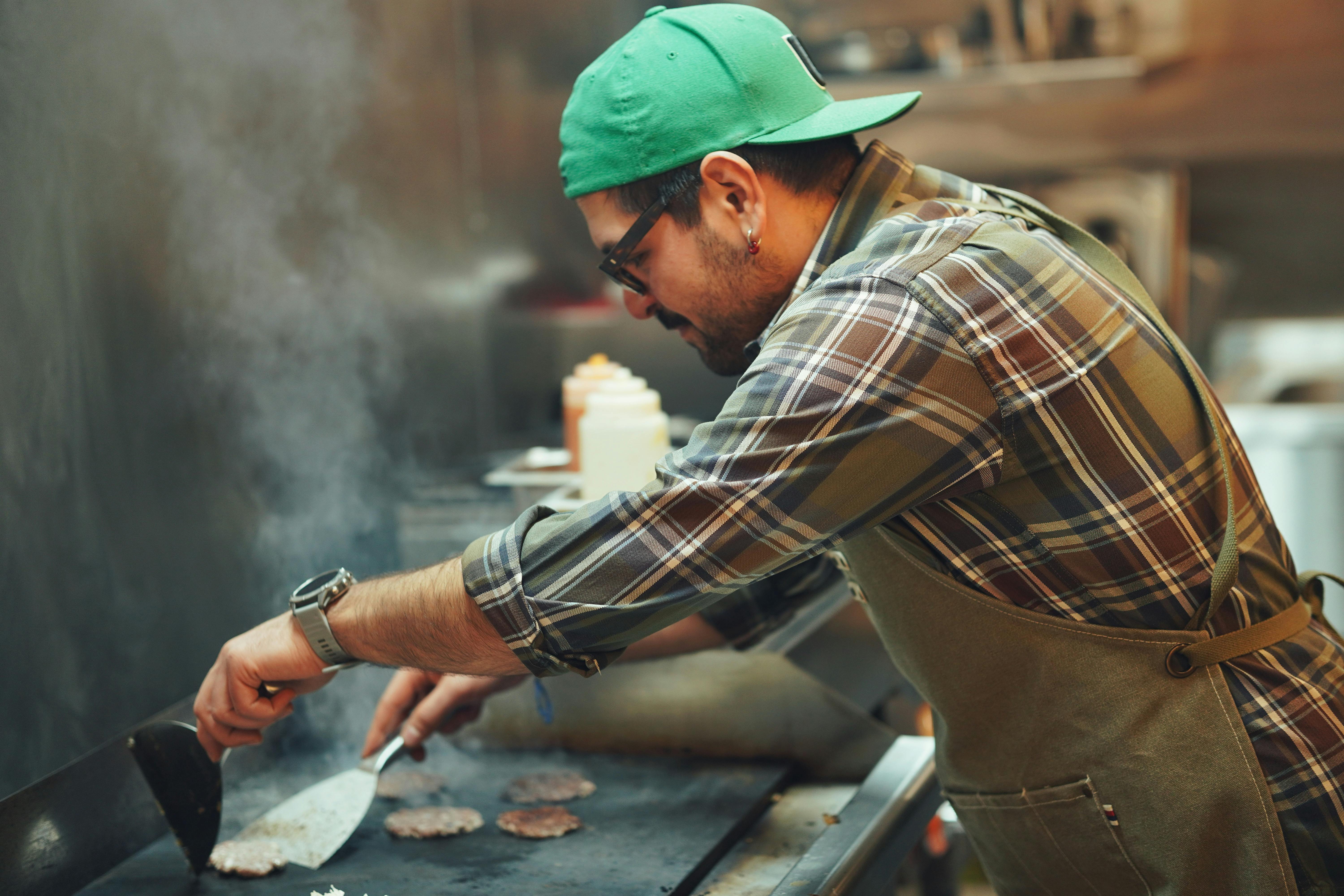 Chef Grilling Burgers in a Busy Kitchen · Free Stock Photo