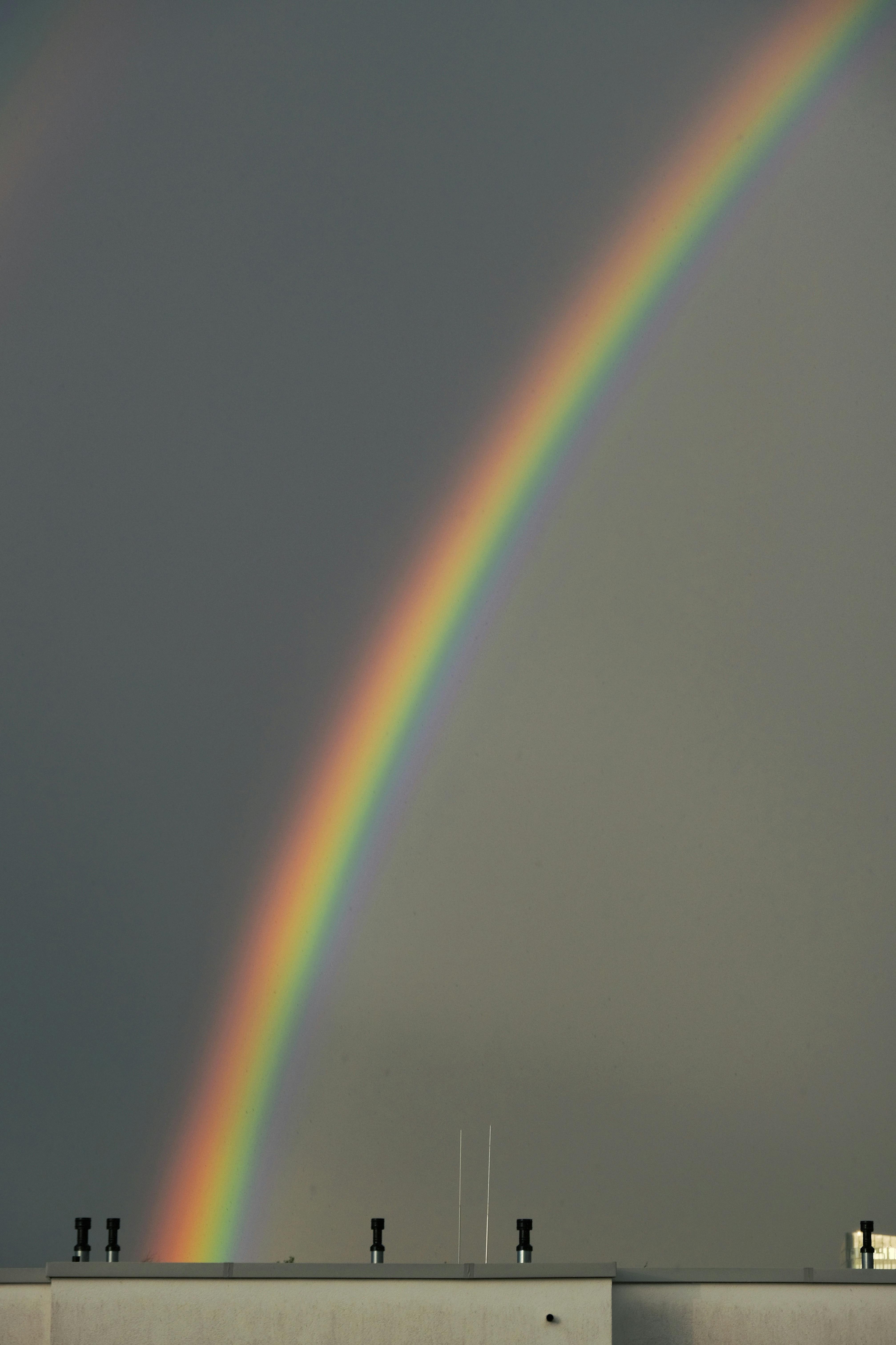 Colorful Rainbow Over Urban Rooftops · Free Stock Photo