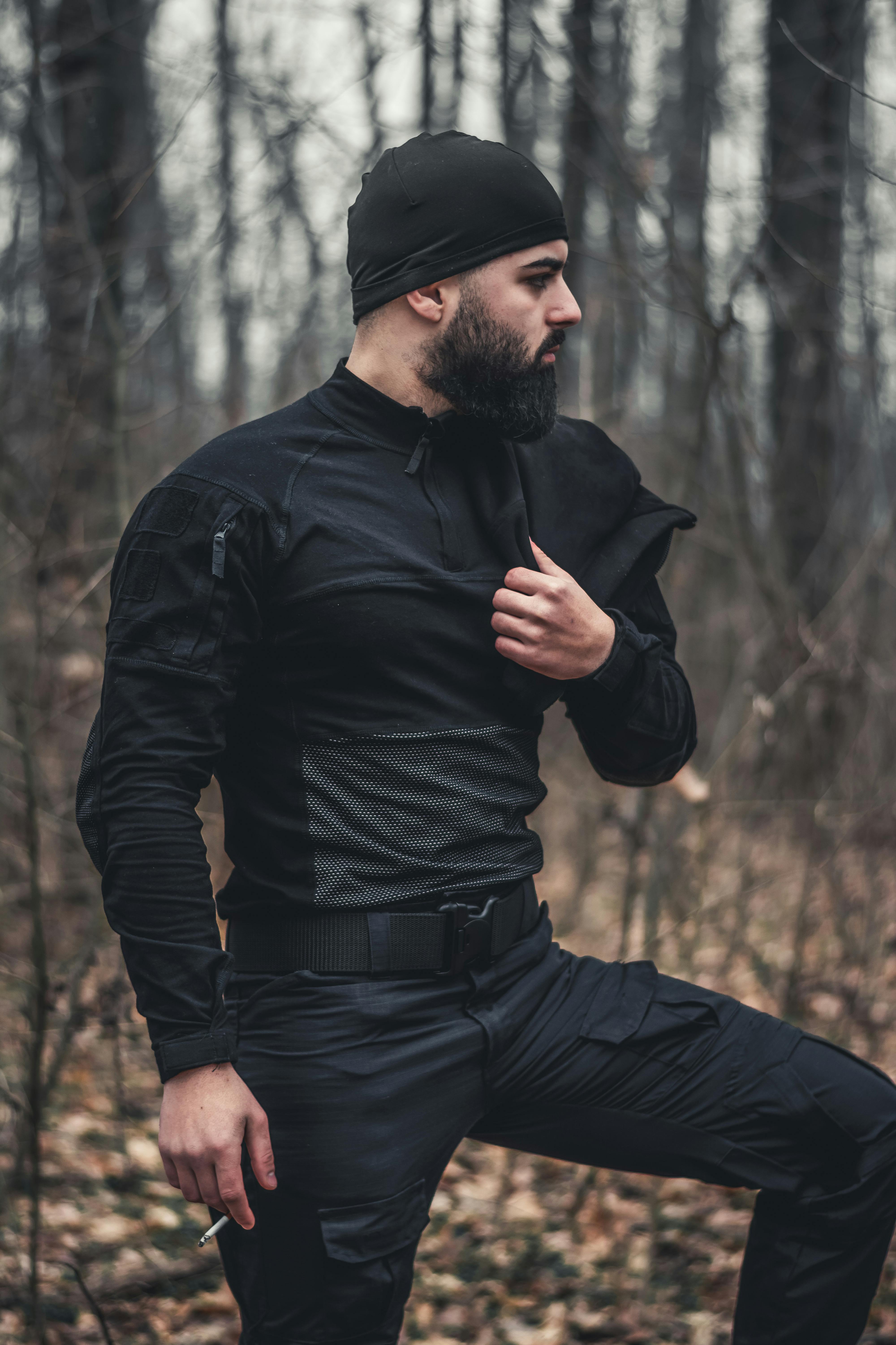 Bearded Man in Tactical Outfit in Forest Setting · Free Stock Photo