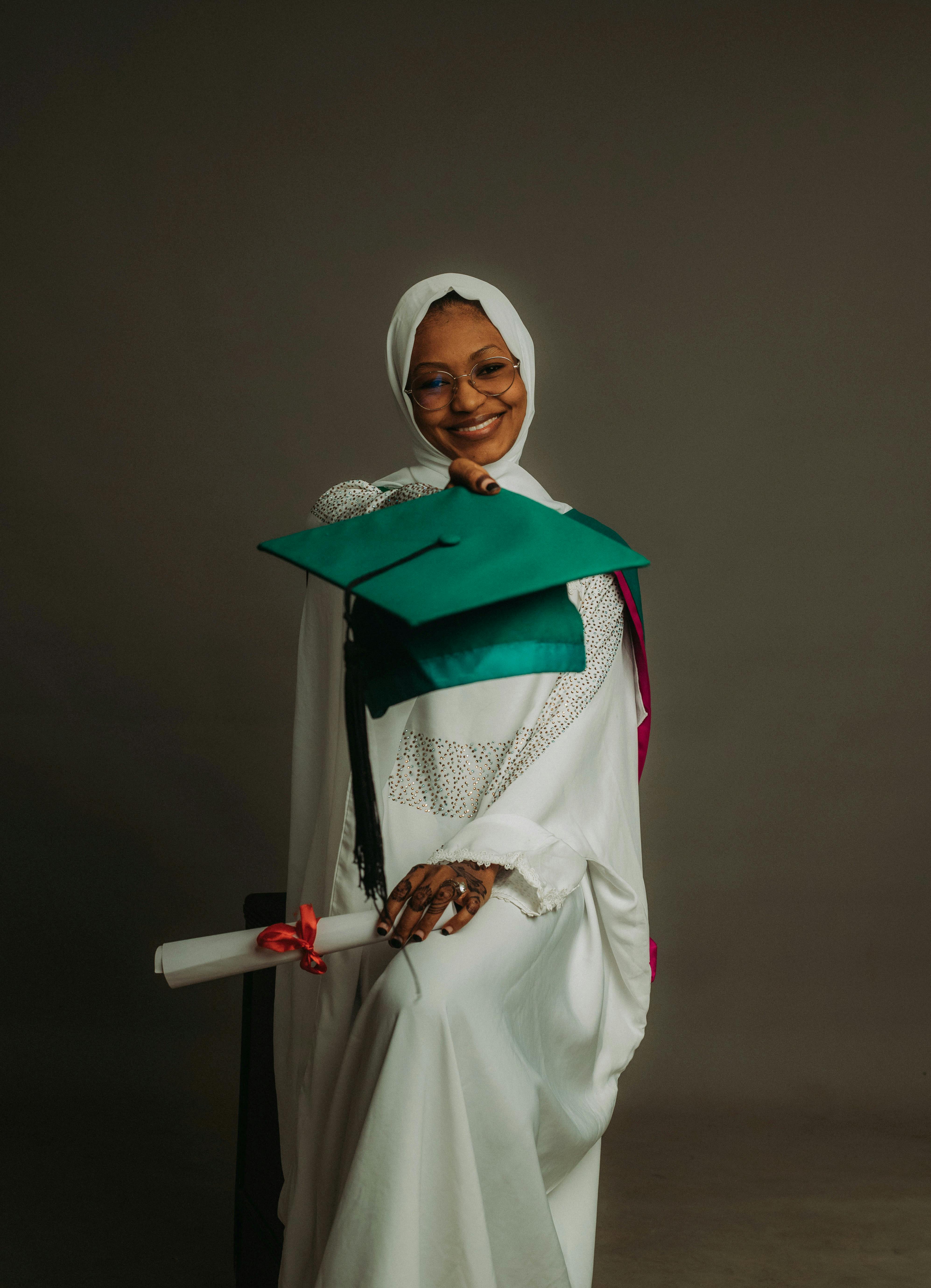 Muslim Graduate Holding Diploma and Graduation Cap · Free Stock Photo