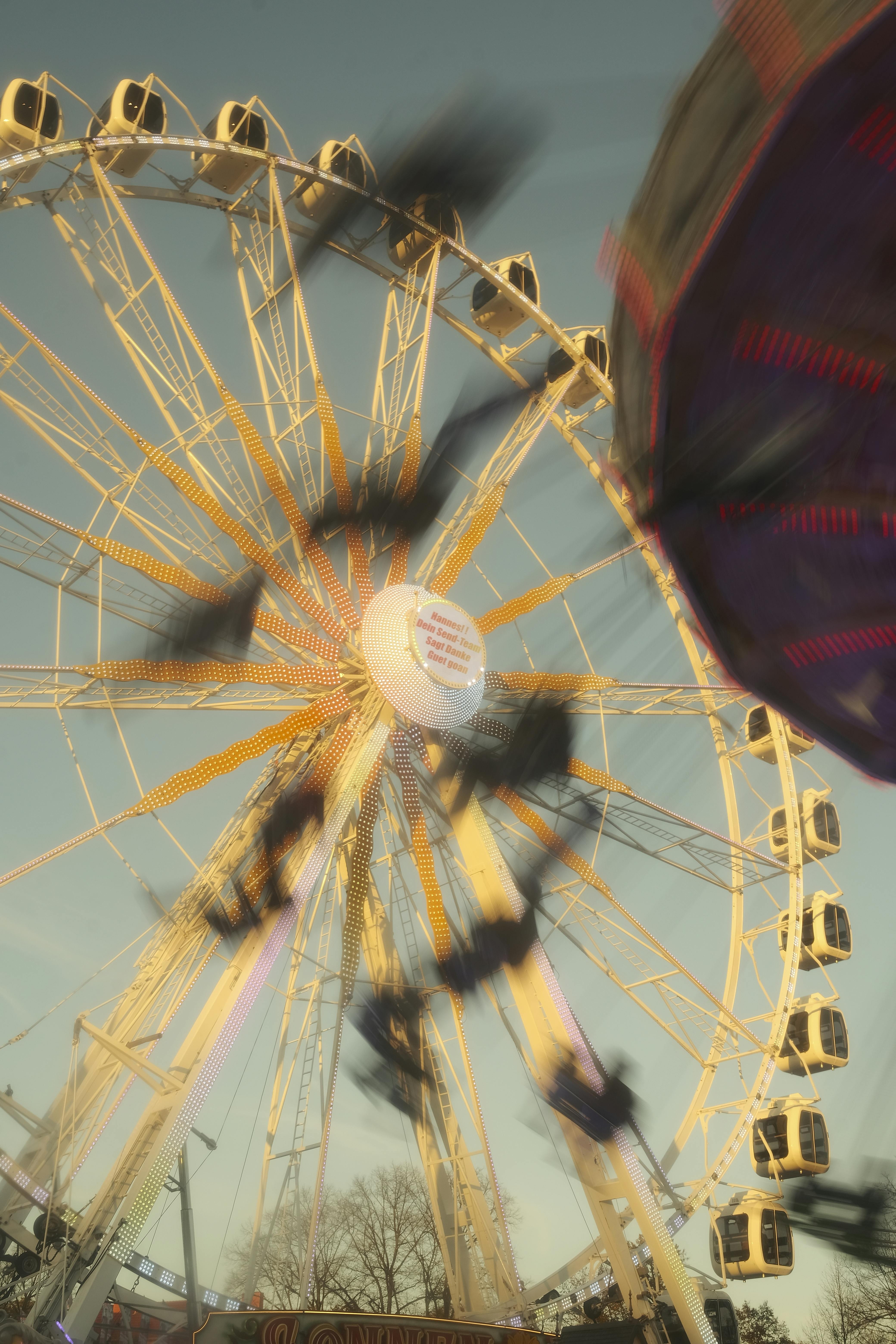 Colorful Ferris Wheel at Dusk with Motion Blur · Free Stock Photo