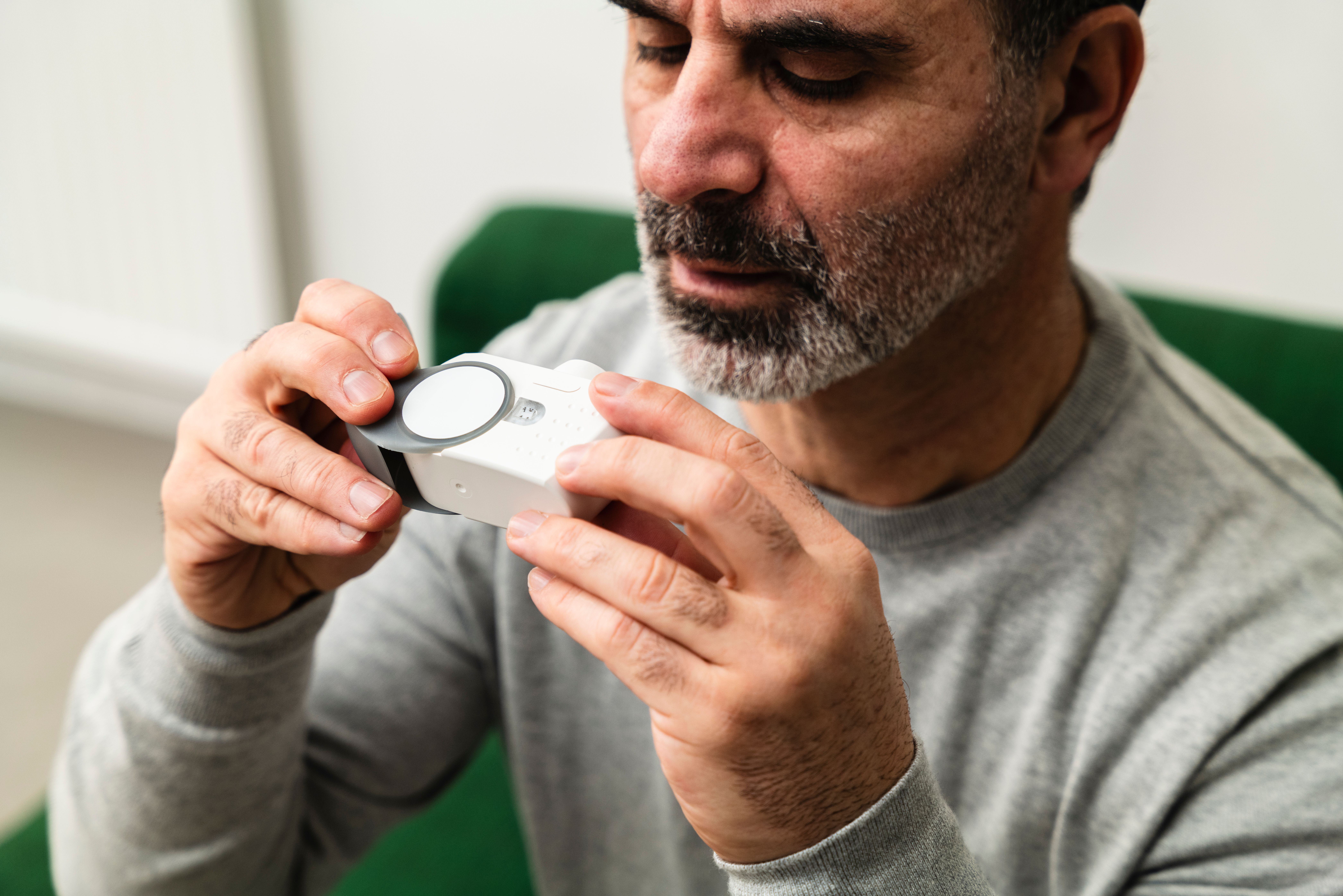 Man Using Medical Device at Home for Health Monitoring · Free Stock Photo