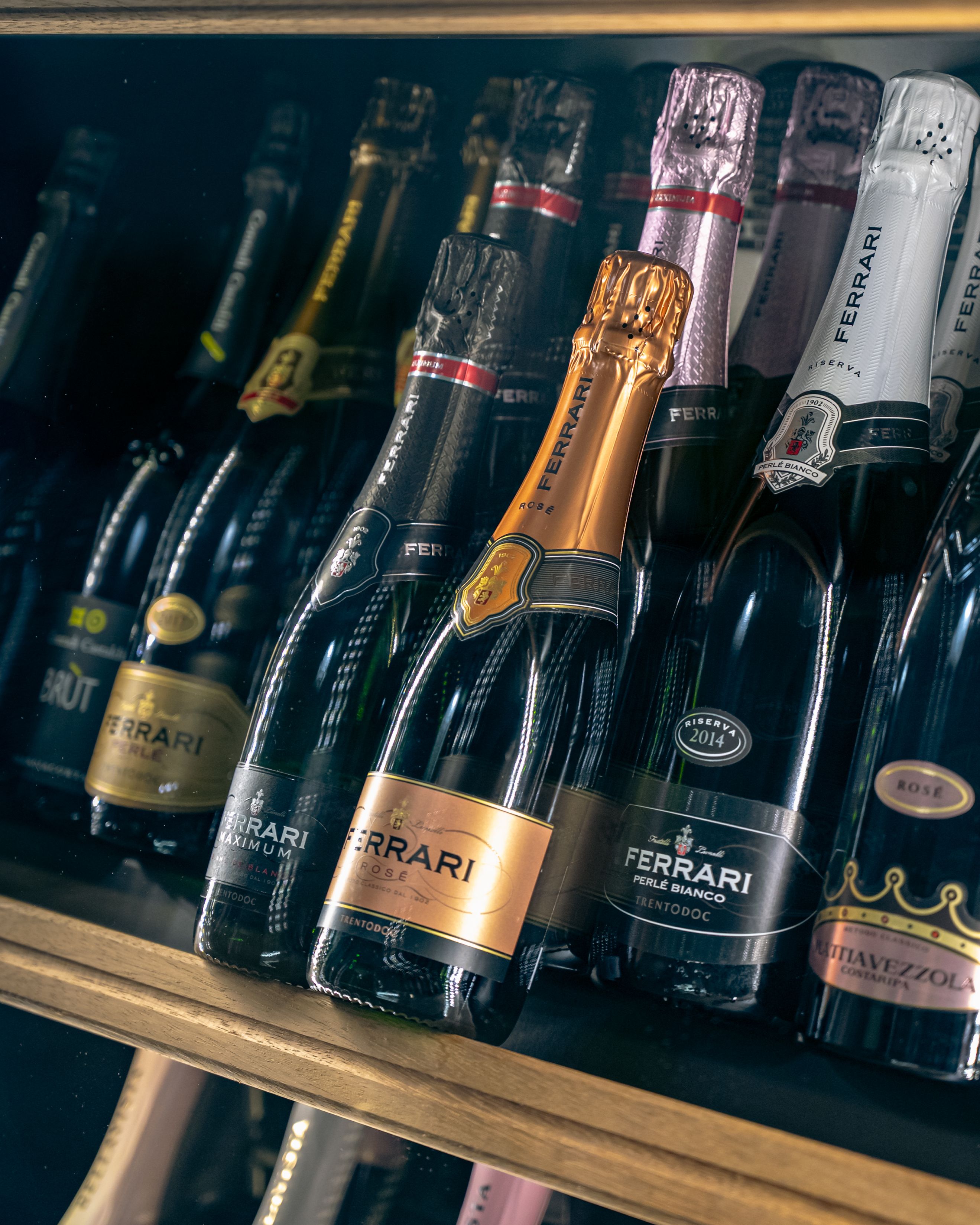 Assorted Sparkling Wine Bottles Displayed in a Shelf · Free Stock Photo