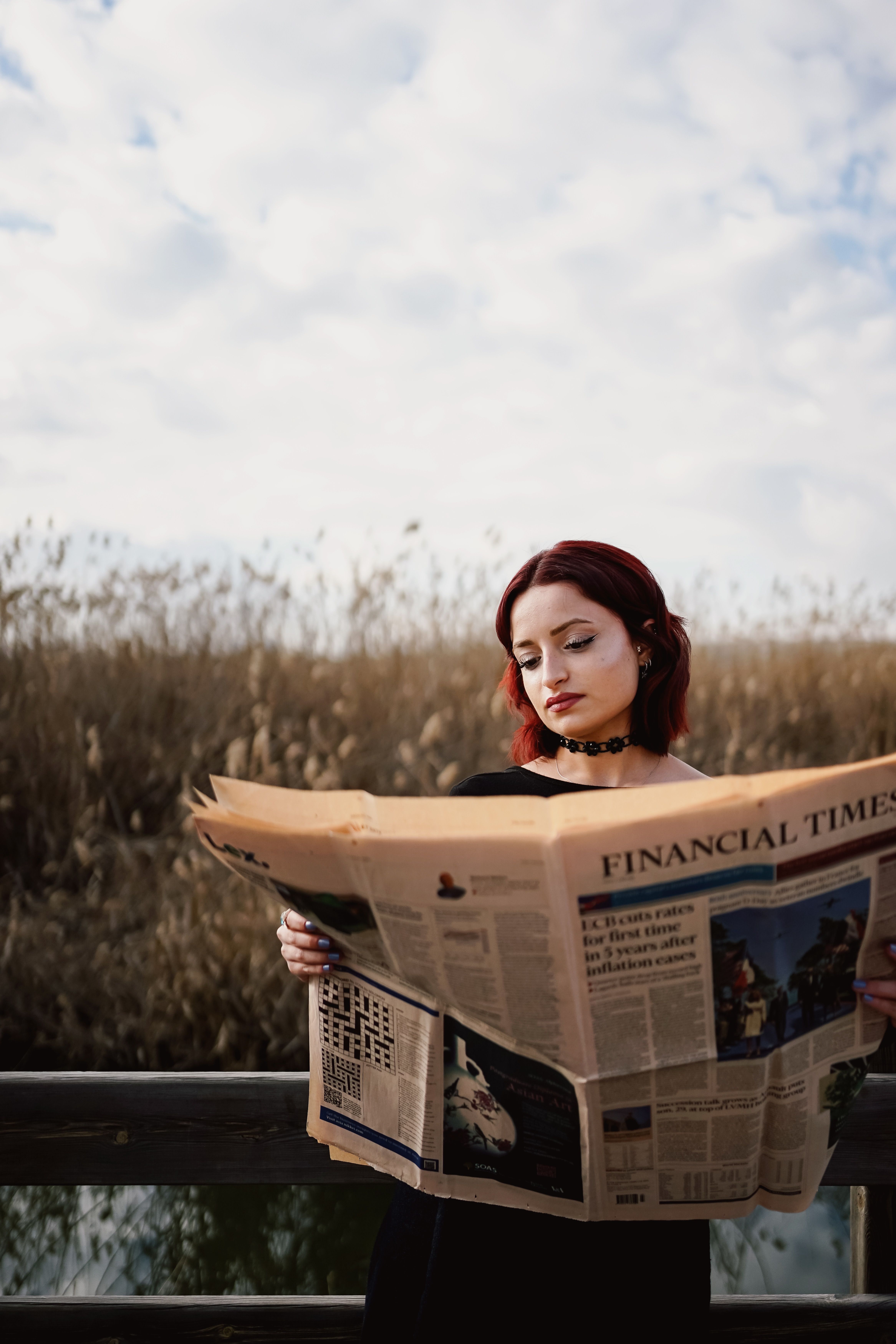 Young Woman Reading Financial Times Outdoors · Free Stock Photo