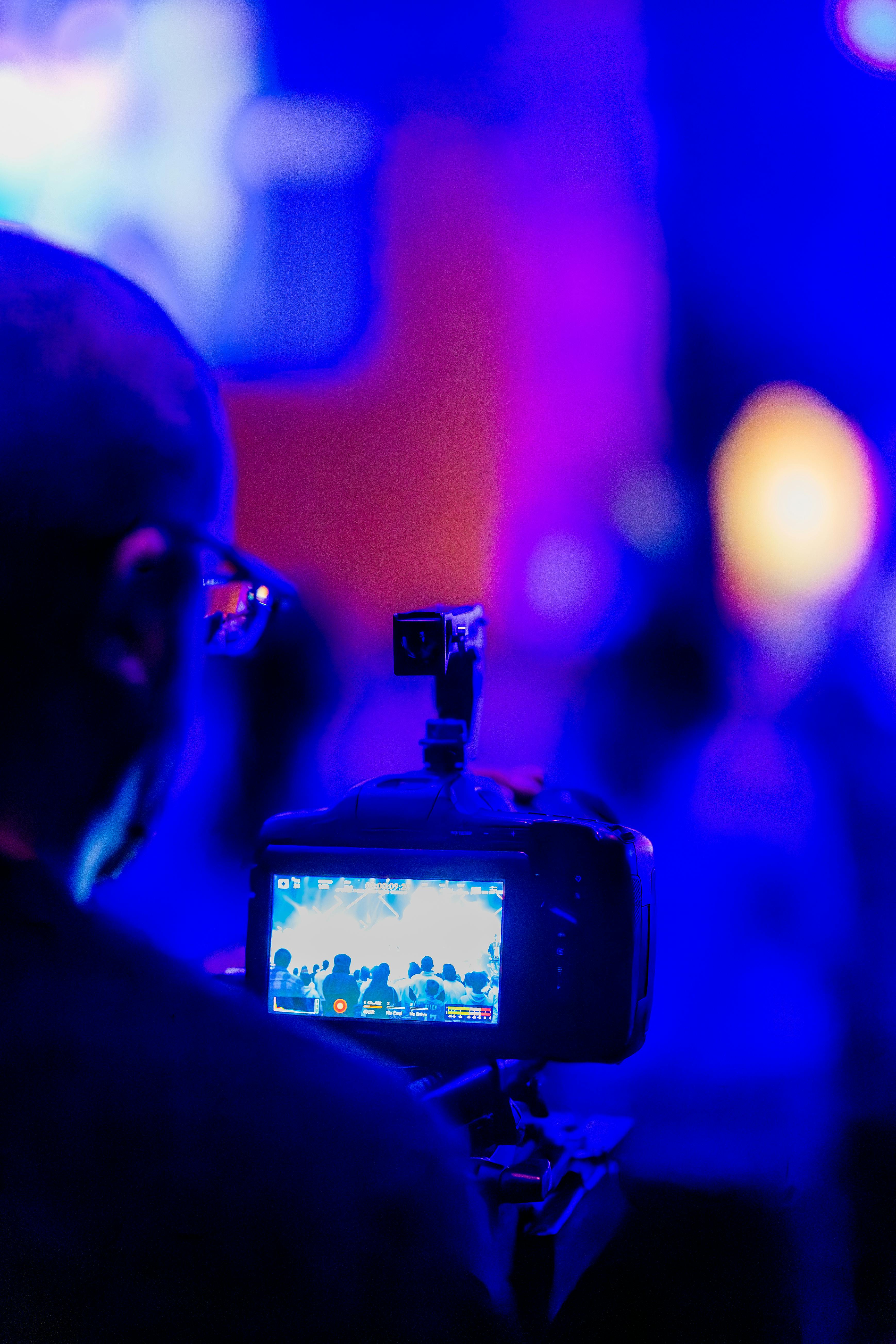 Cameraman Filming at a Vibrant Event · Free Stock Photo