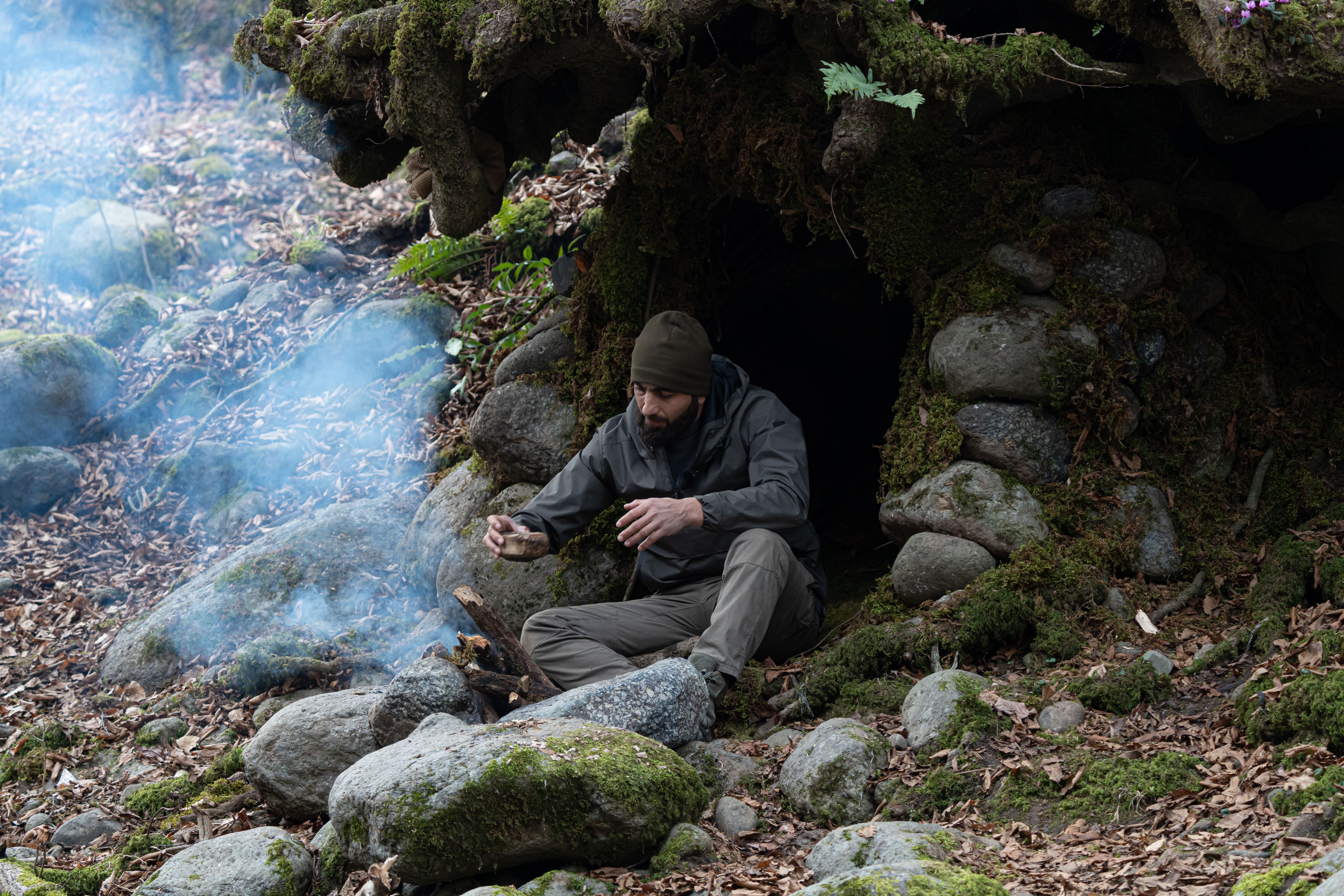 Hombre Acampando En El Bosque Con Un Refugio De Piedra · Foto de stock ...