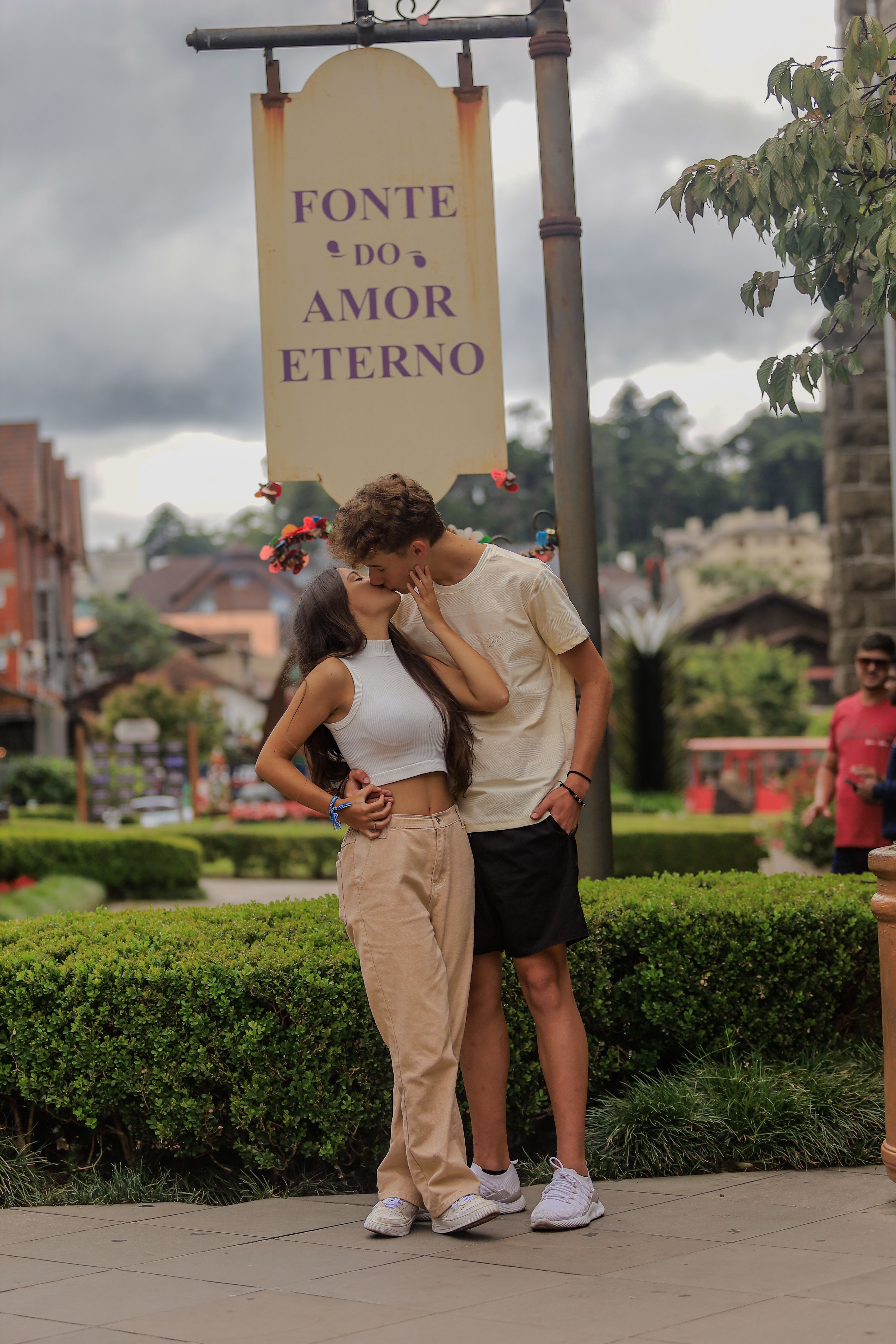 Romantic Couple in Front of 'Fonte do Amor Eterno' Sign · Free Stock Photo