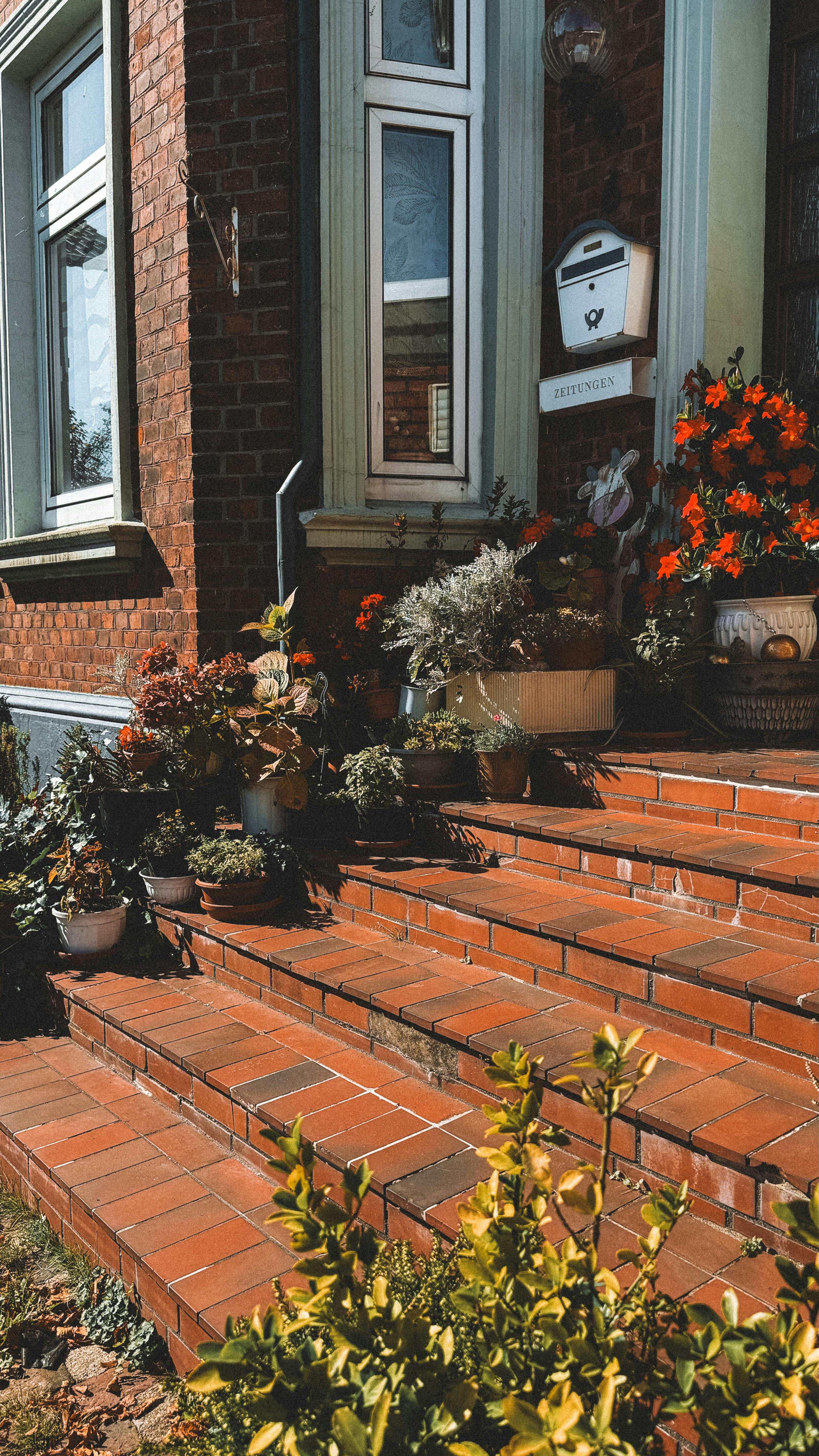 Charming Red Brick Entrance with Flower Pots · Free Stock Photo