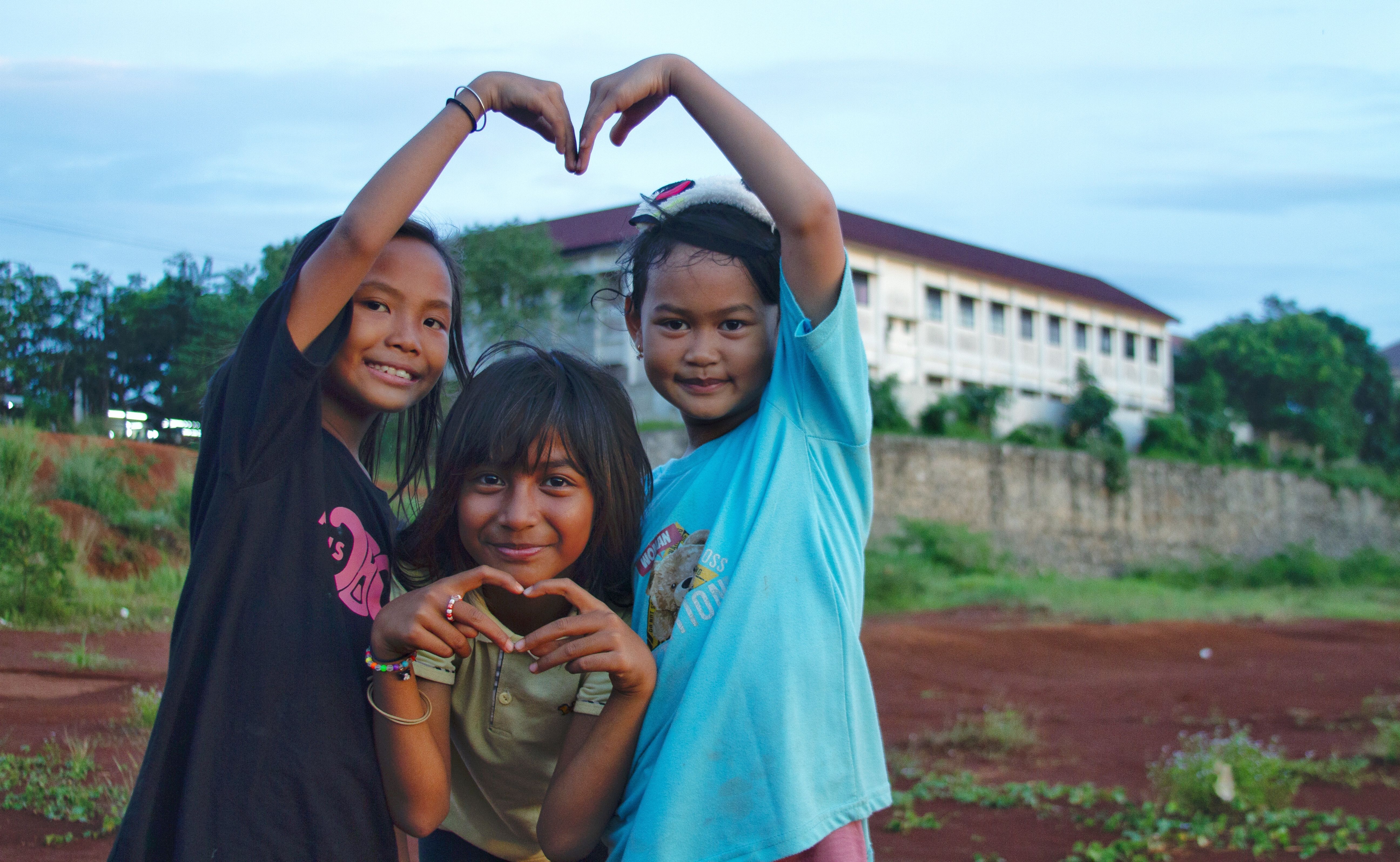 Three kids forming heart shape outdoors · Free Stock Photo