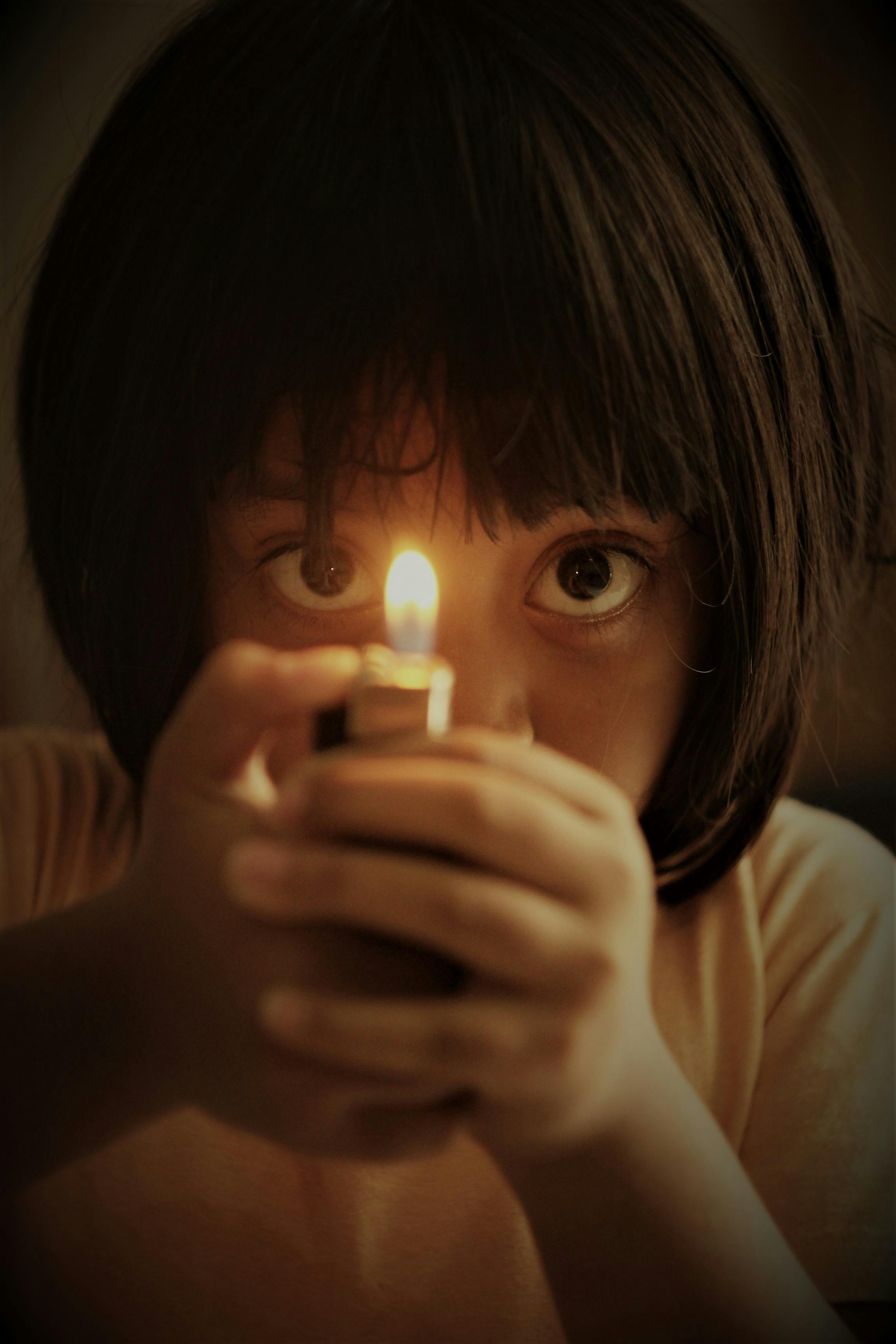 Child Gazing at Flickering Lighter Flame · Free Stock Photo