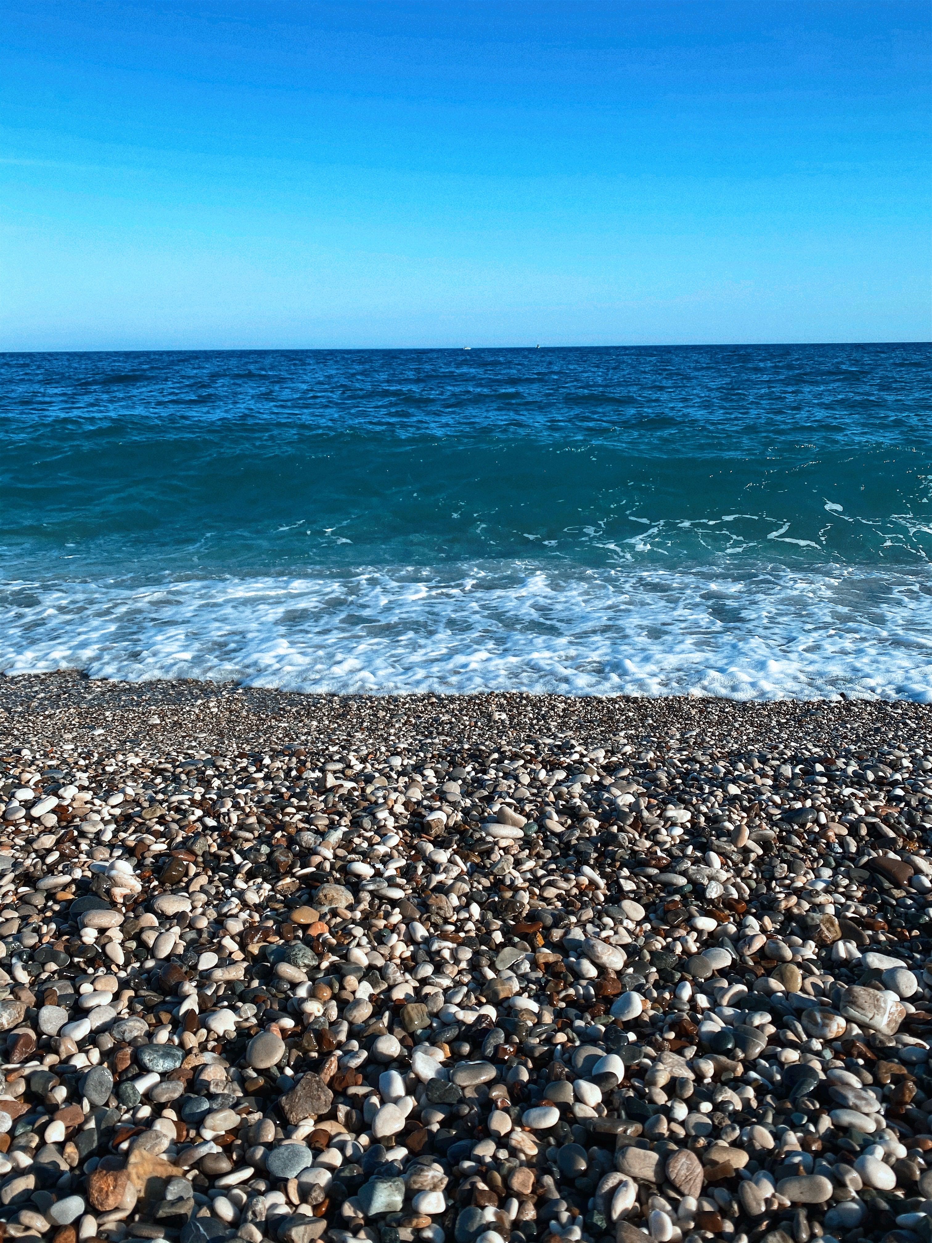 Idyllic Pebble Beach with Clear Blue Ocean · Free Stock Photo