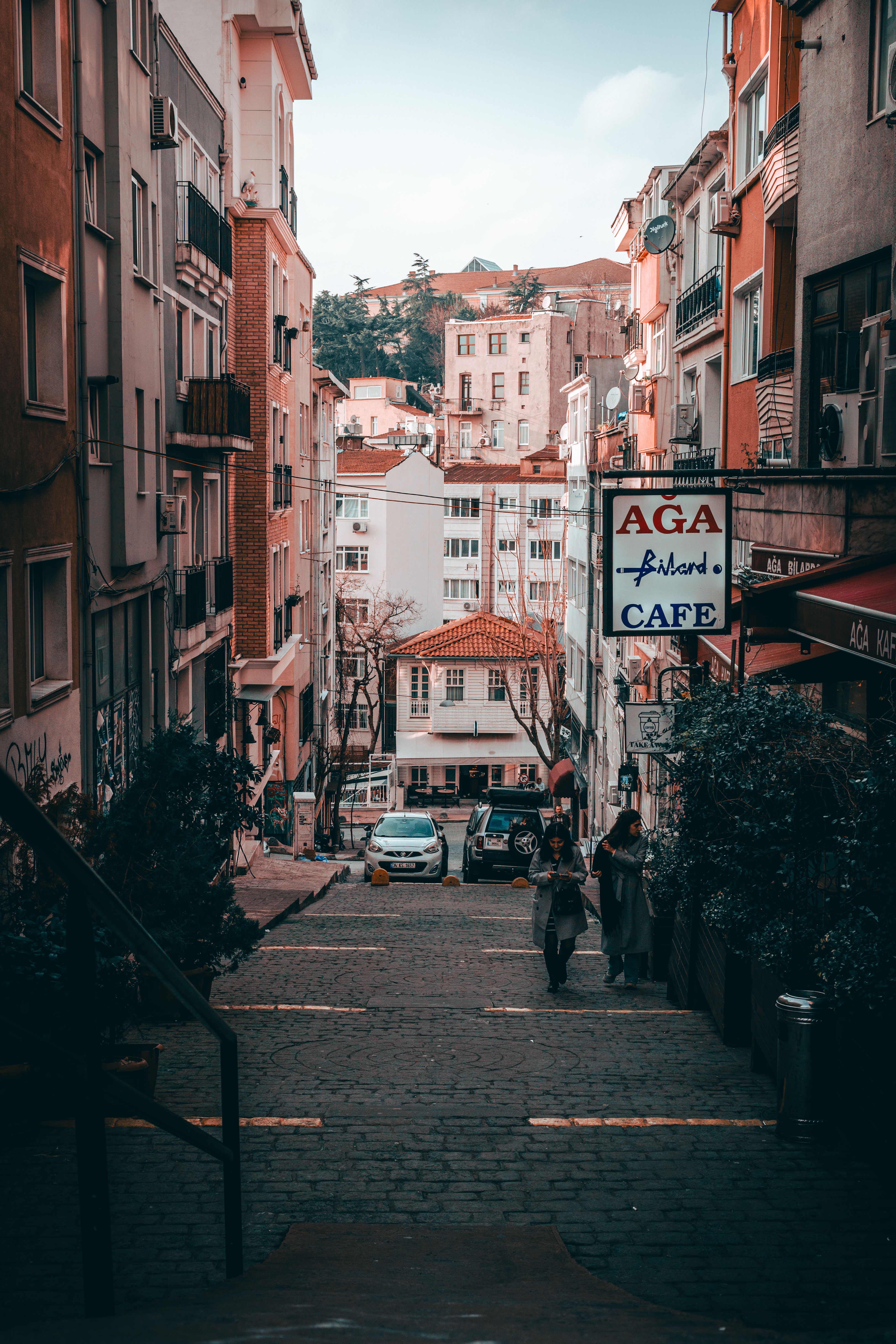 Charming European Street with Quaint Café Signs · Free Stock Photo