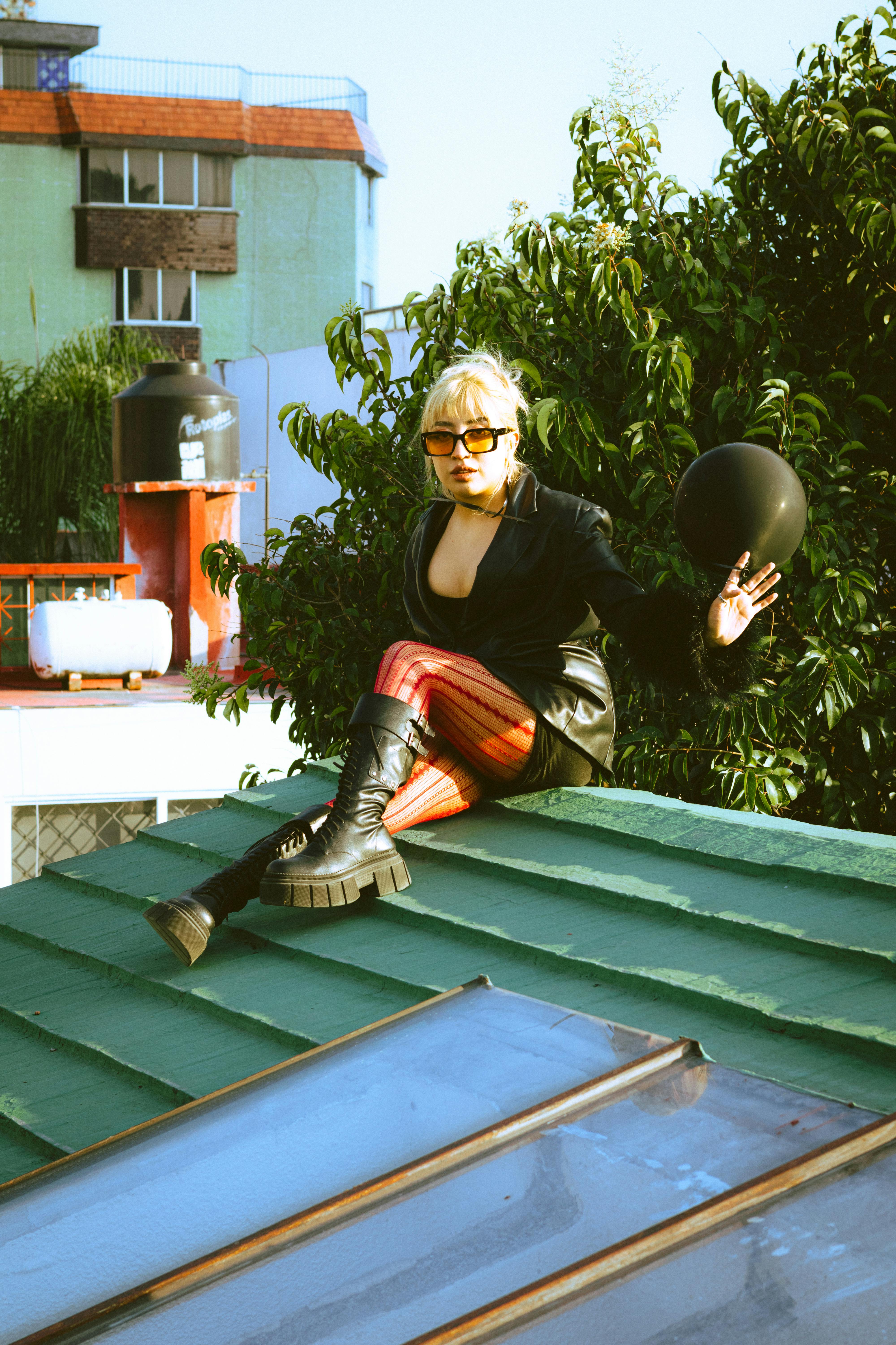 Stylish Woman Posing on Rooftop with Balloon · Free Stock Photo