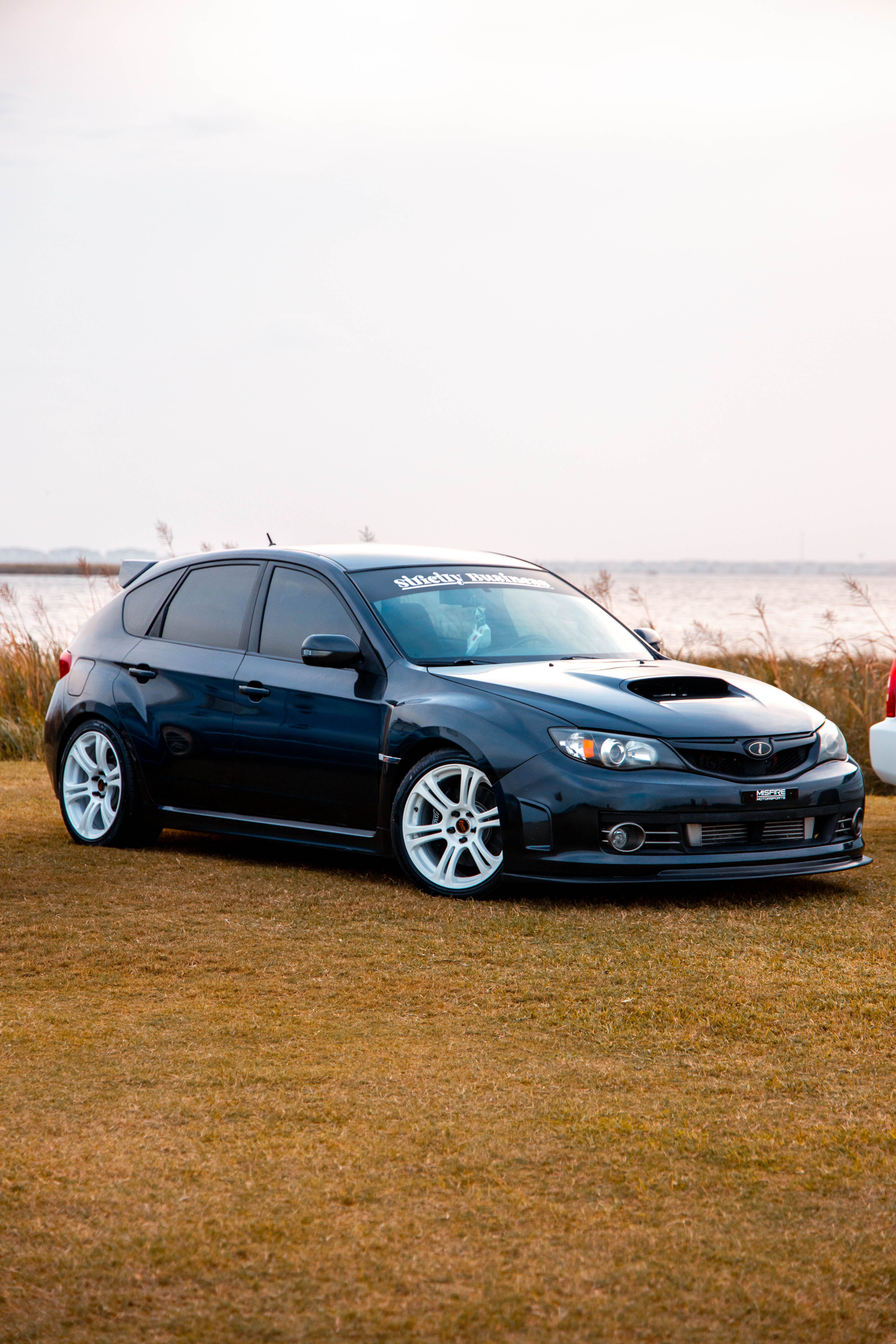 Black Hatchback Car Parked on Grassy Field · Free Stock Photo