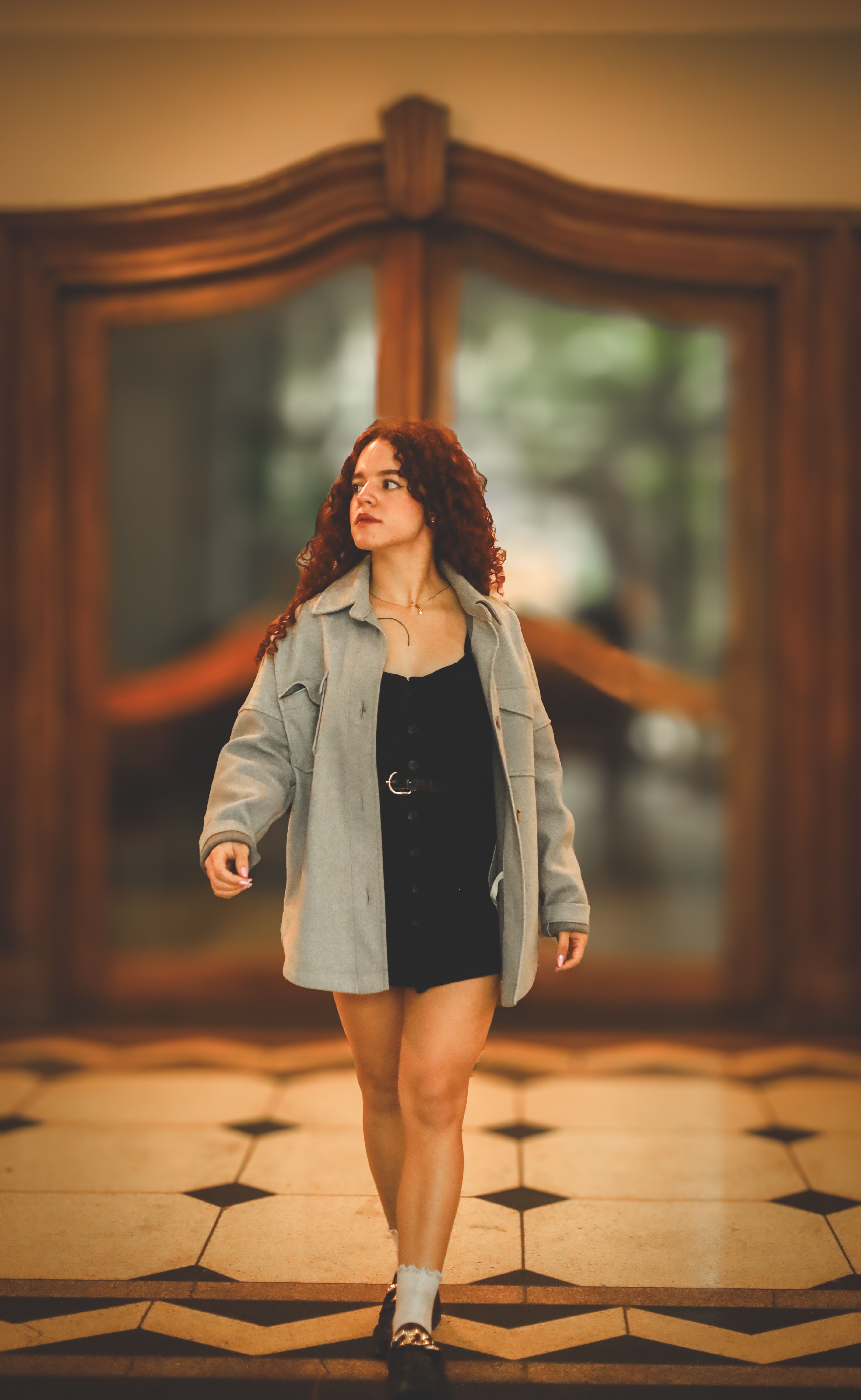 Young Woman in Stylish Outfit Walking Indoors · Free Stock Photo