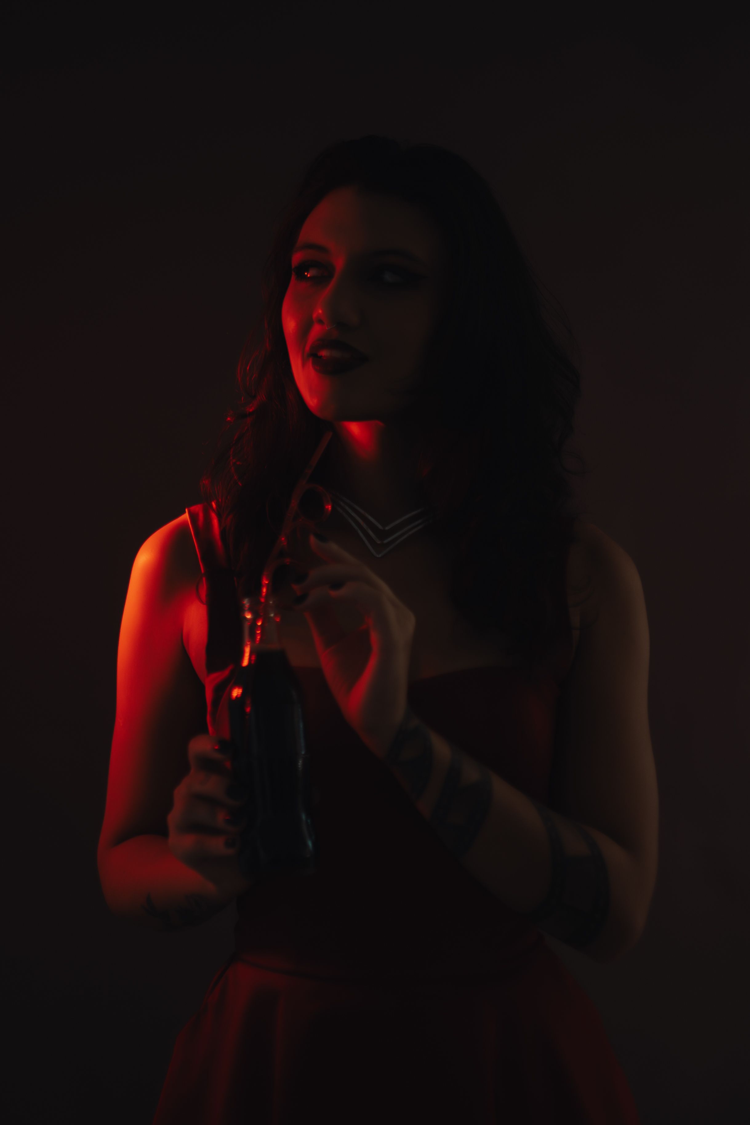 Moody Red Light Portrait of Woman Holding Drink · Free Stock Photo