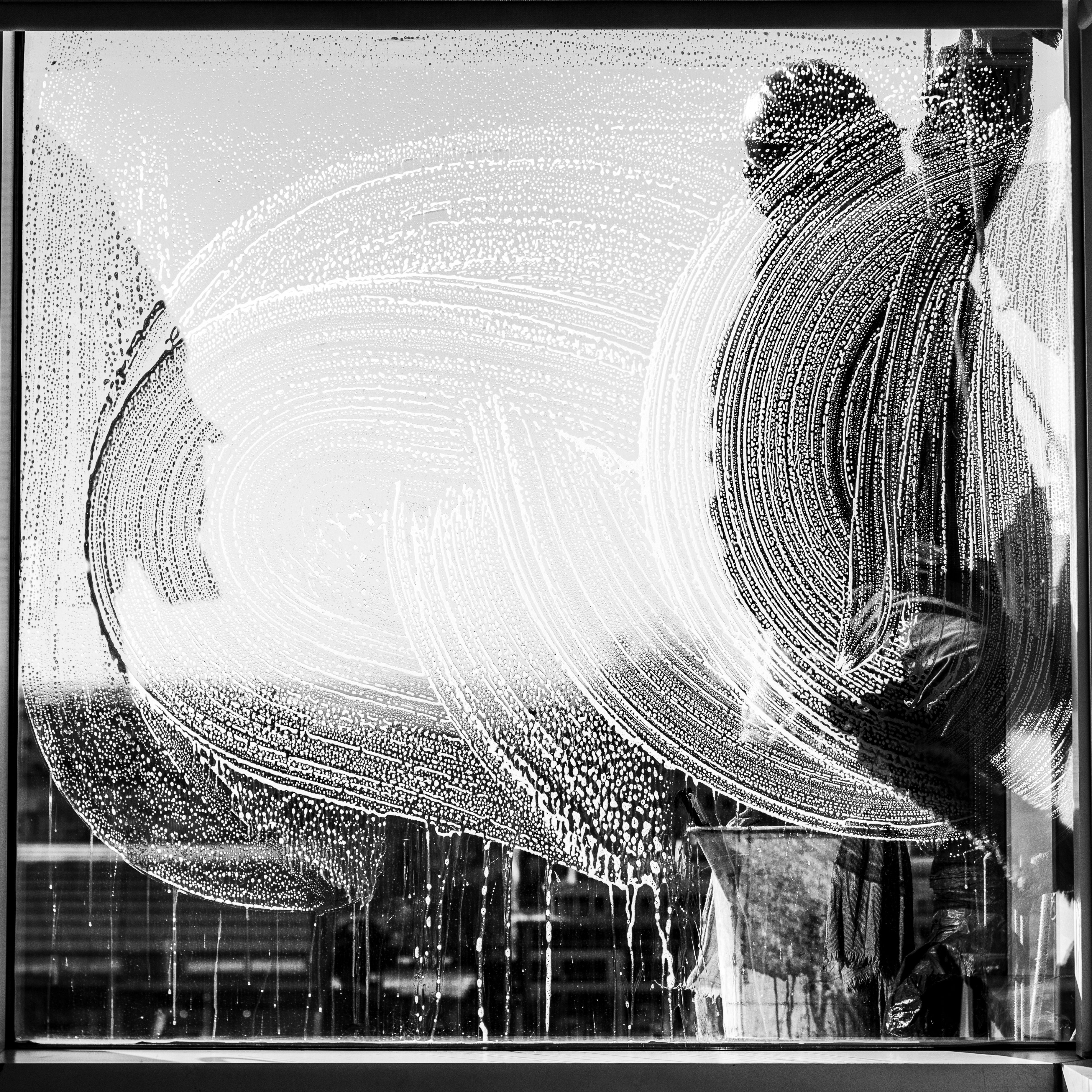 Urban Worker Cleaning City Window in Black and White · Free Stock Photo