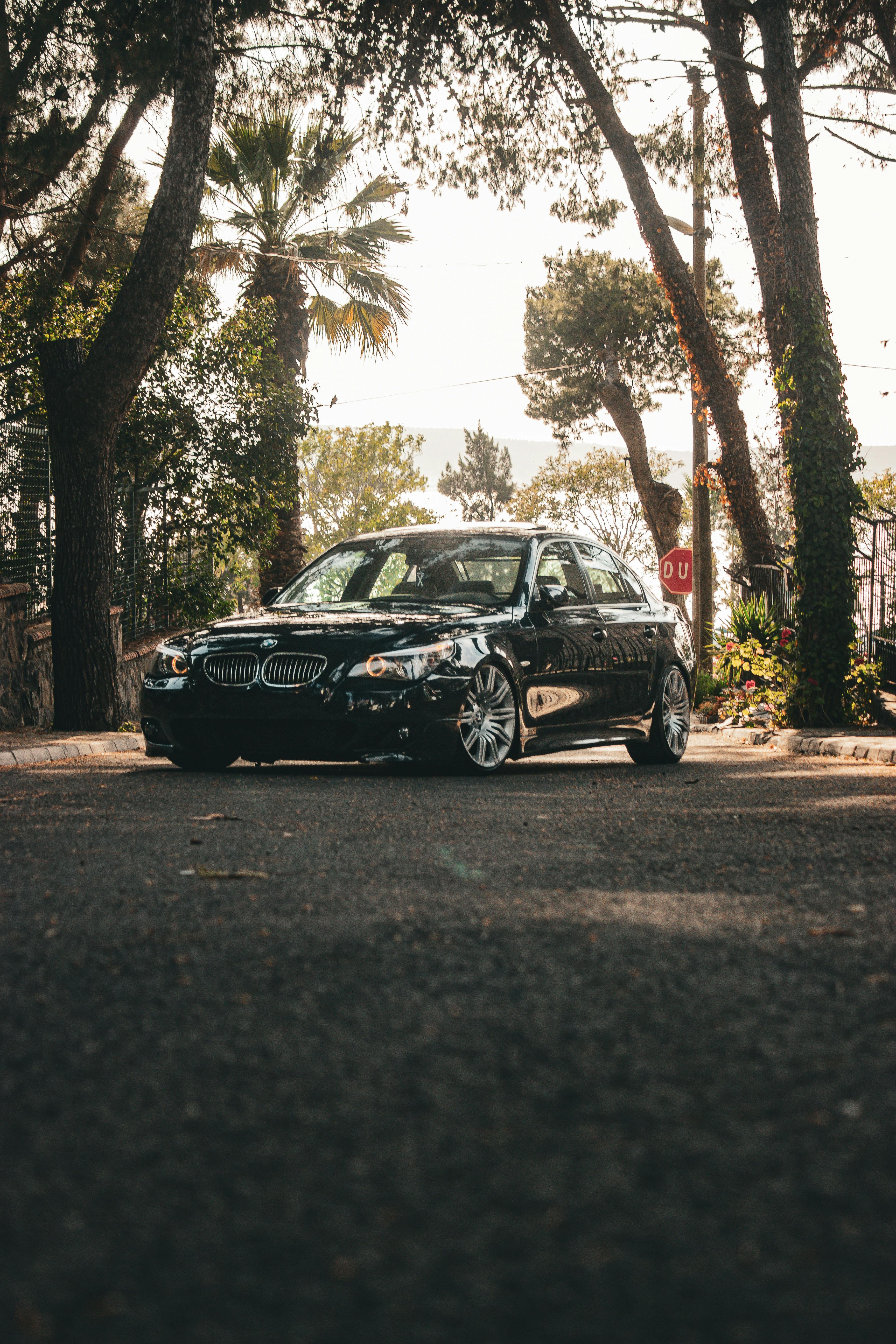Sleek Black Car Parked on Sunlit Street in İzmir · Free Stock Photo