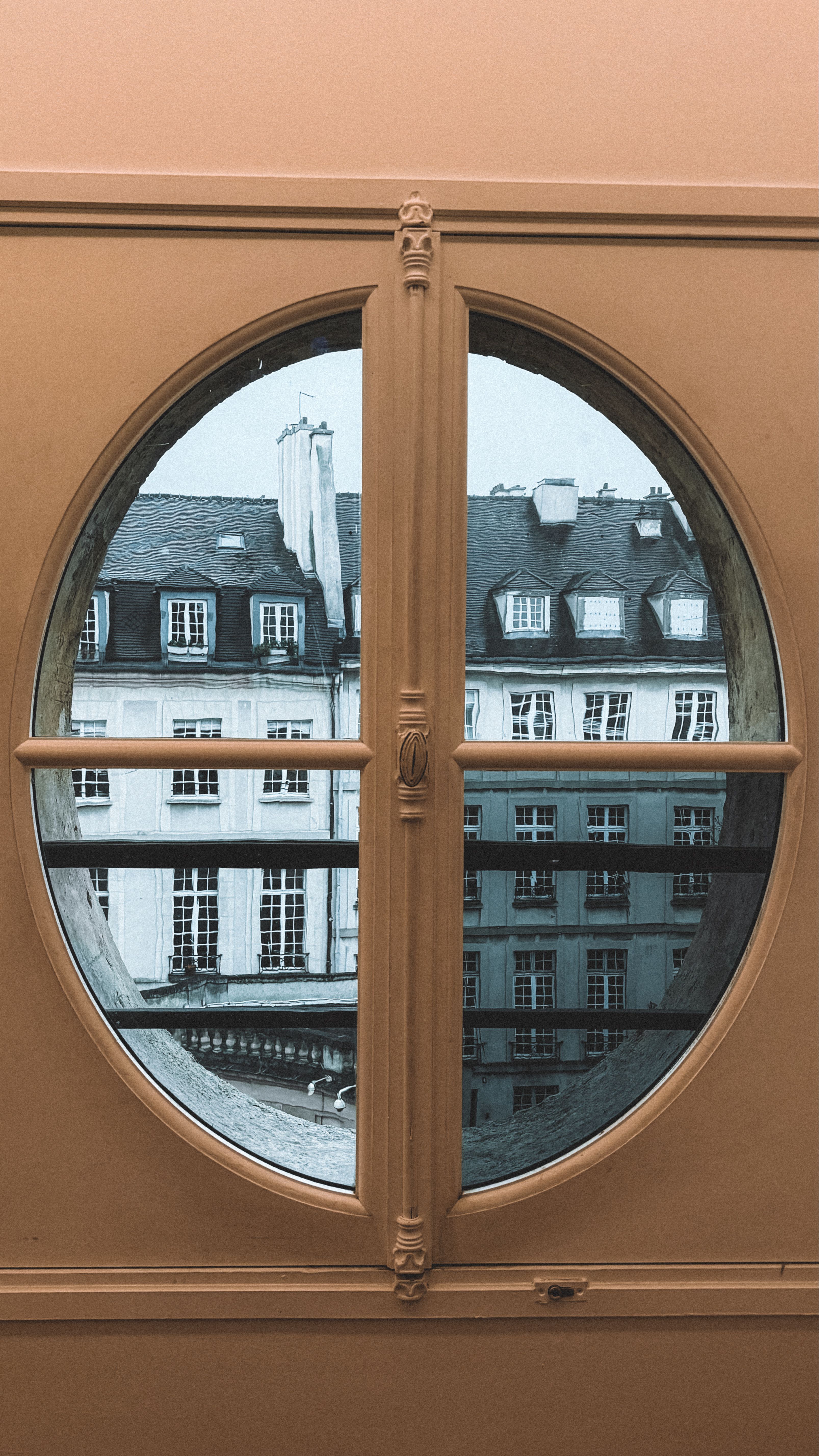 Vintage Oval Window View of Classic Architecture · Free Stock Photo