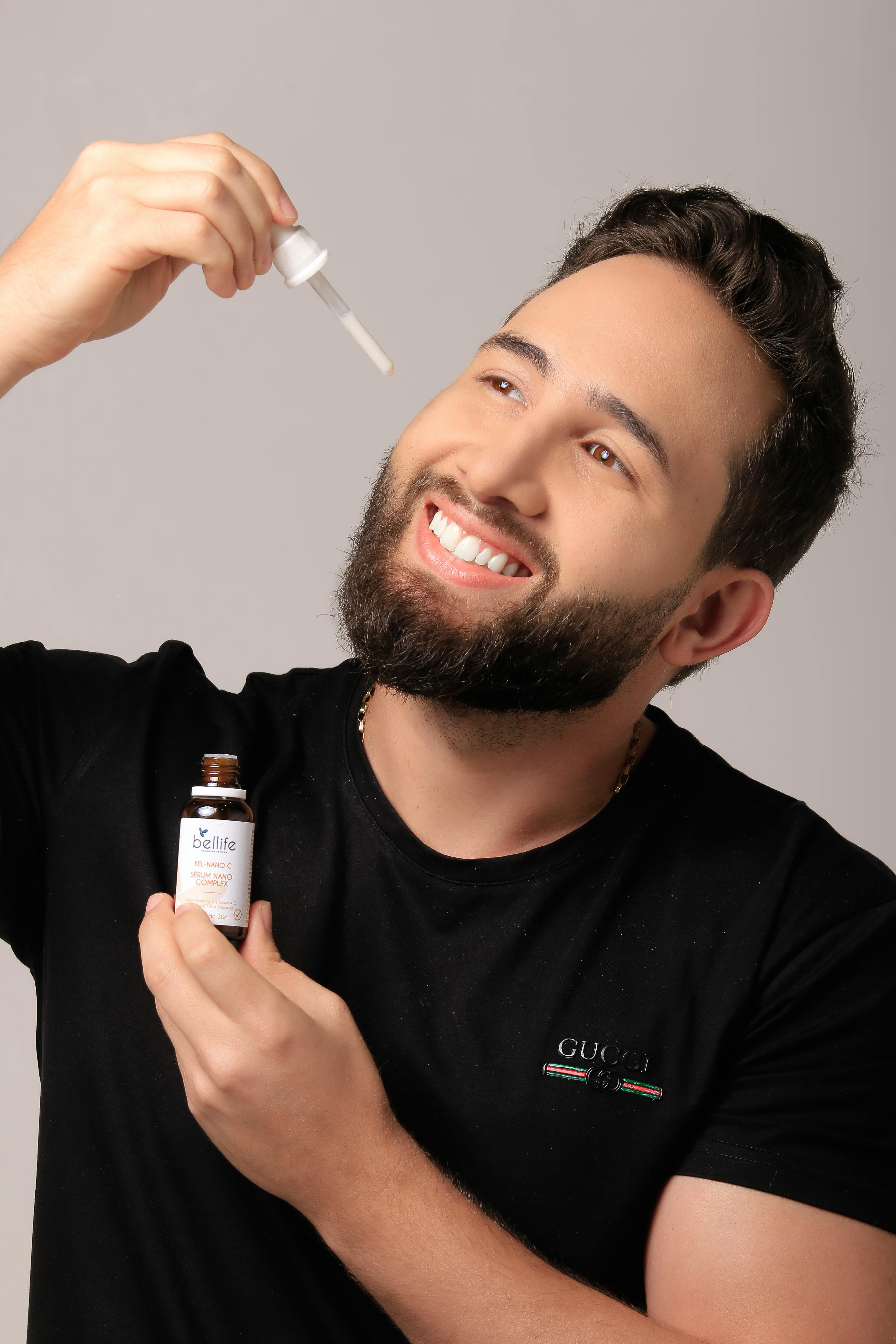 Man Applying Beard Oil with Dropper · Free Stock Photo