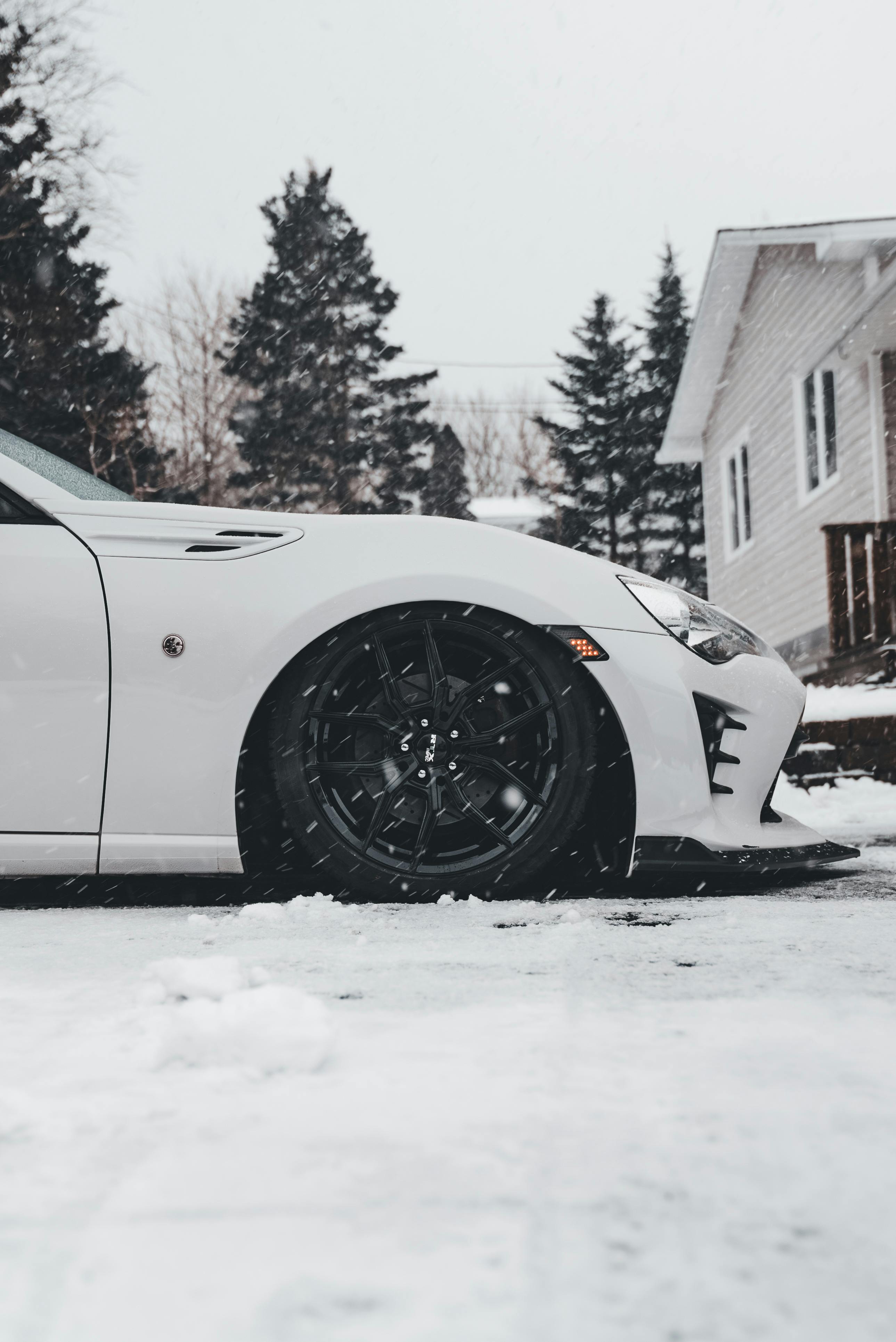 Sleek Sports Car in Snowy Suburban Setting · Free Stock Photo