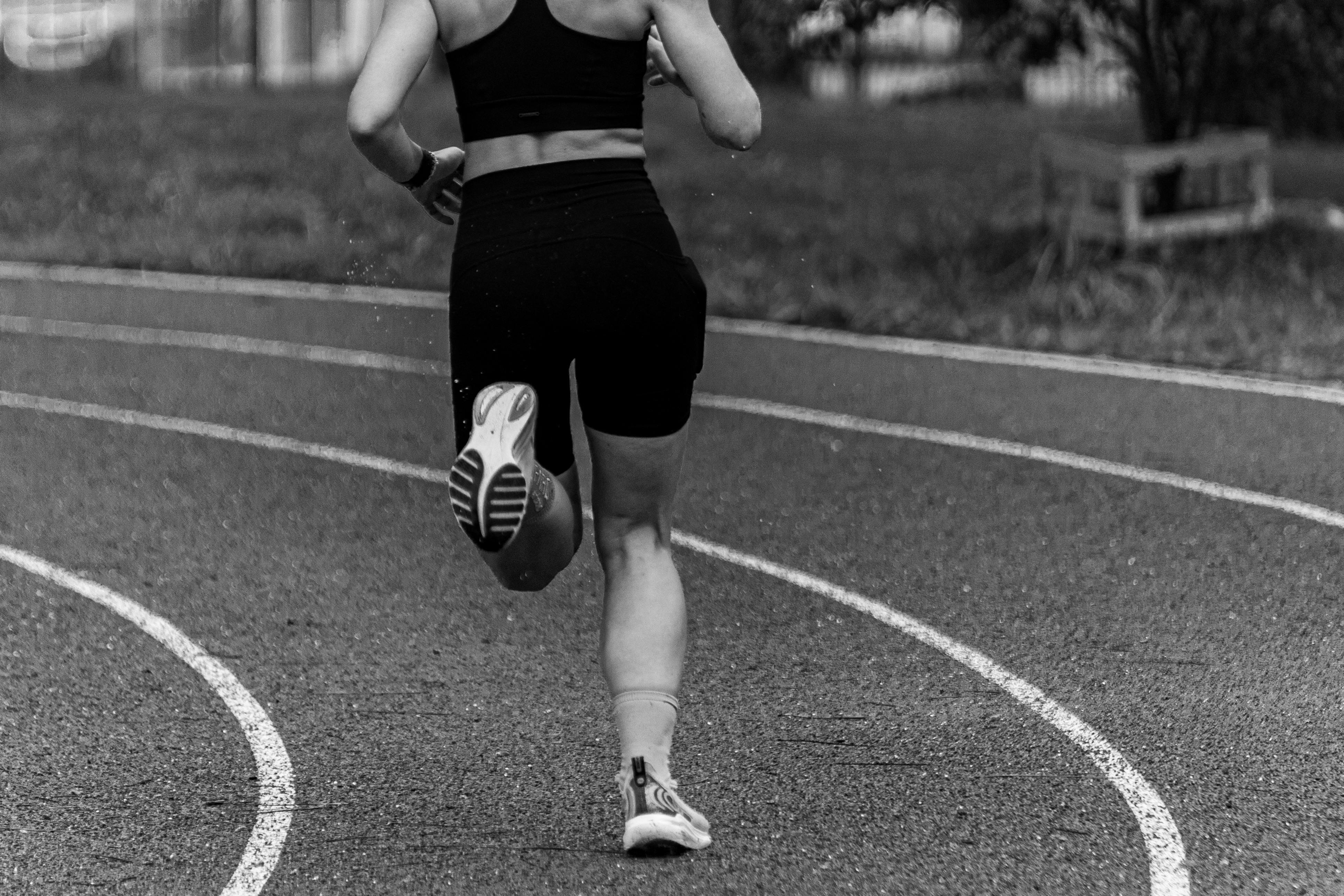 Cropped View of Runner on Track in Black and White · Free Stock Photo