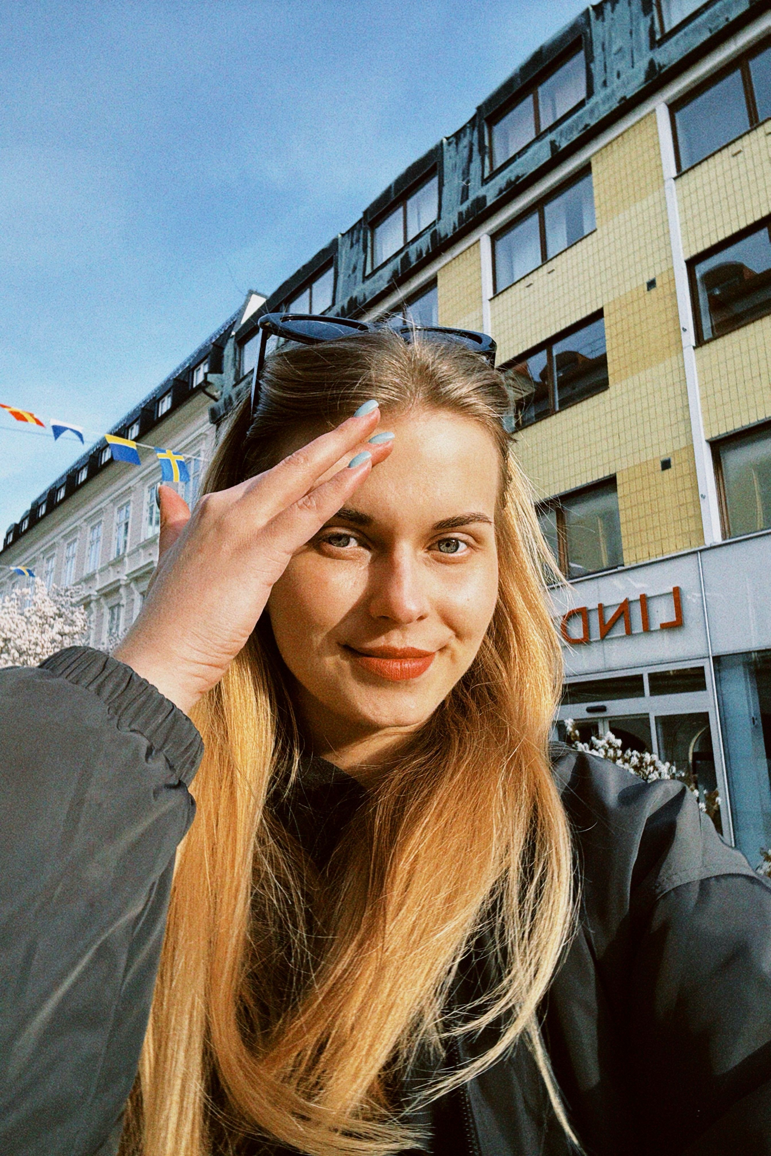 Smiling Woman Outdoors in Swedish Urban Scene · Free Stock Photo