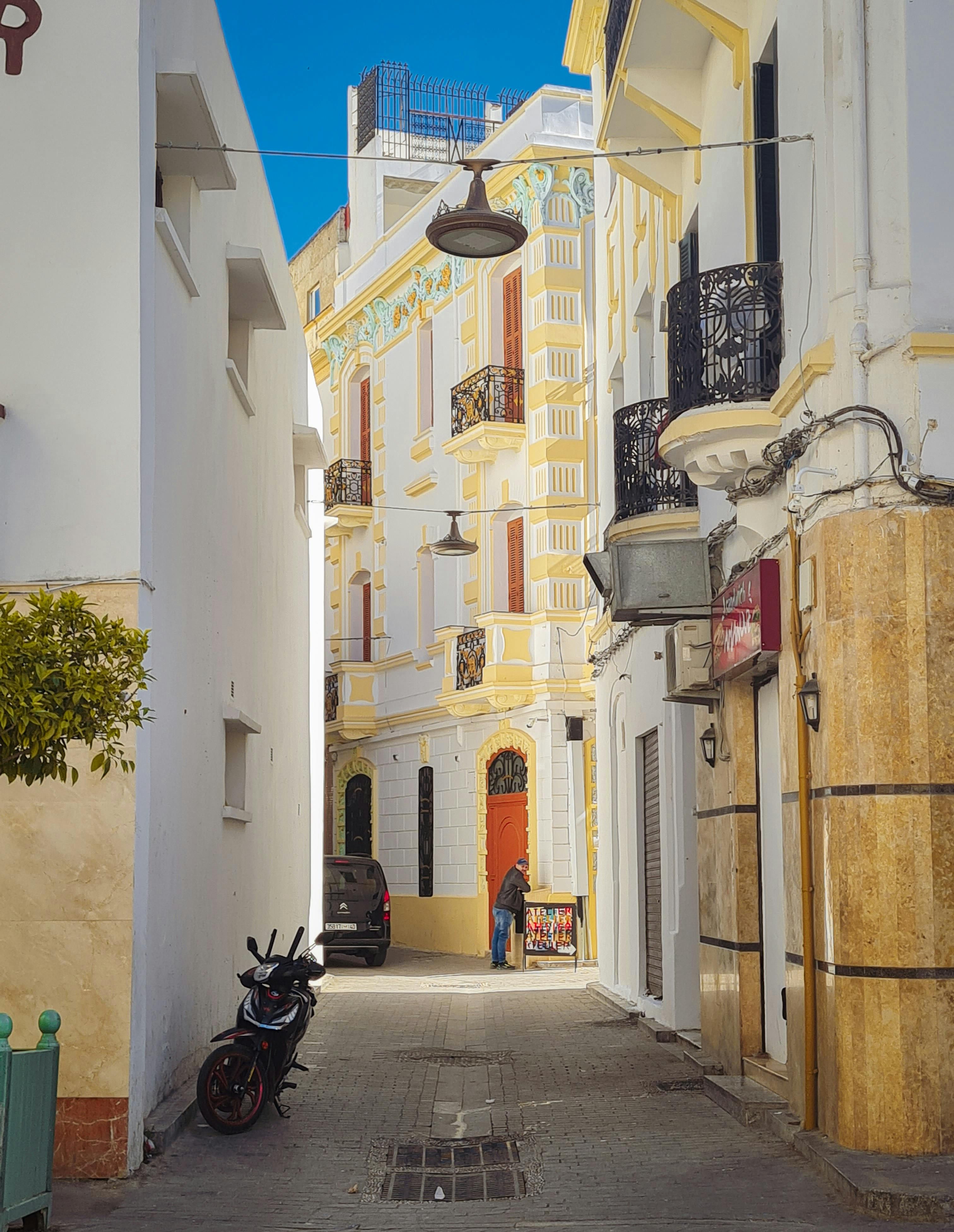 Narrow Street with Vibrant Sunlit Architecture · Free Stock Photo