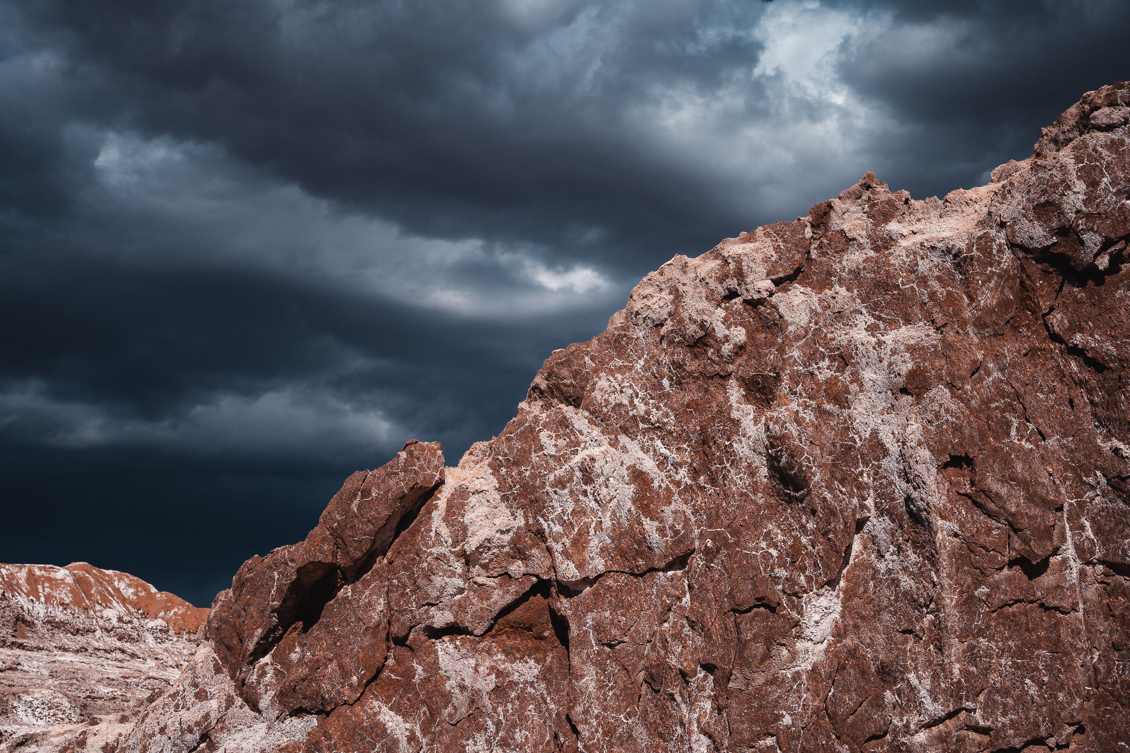 Dramatic Rocky Cliff Against Stormy Sky · Free Stock Photo