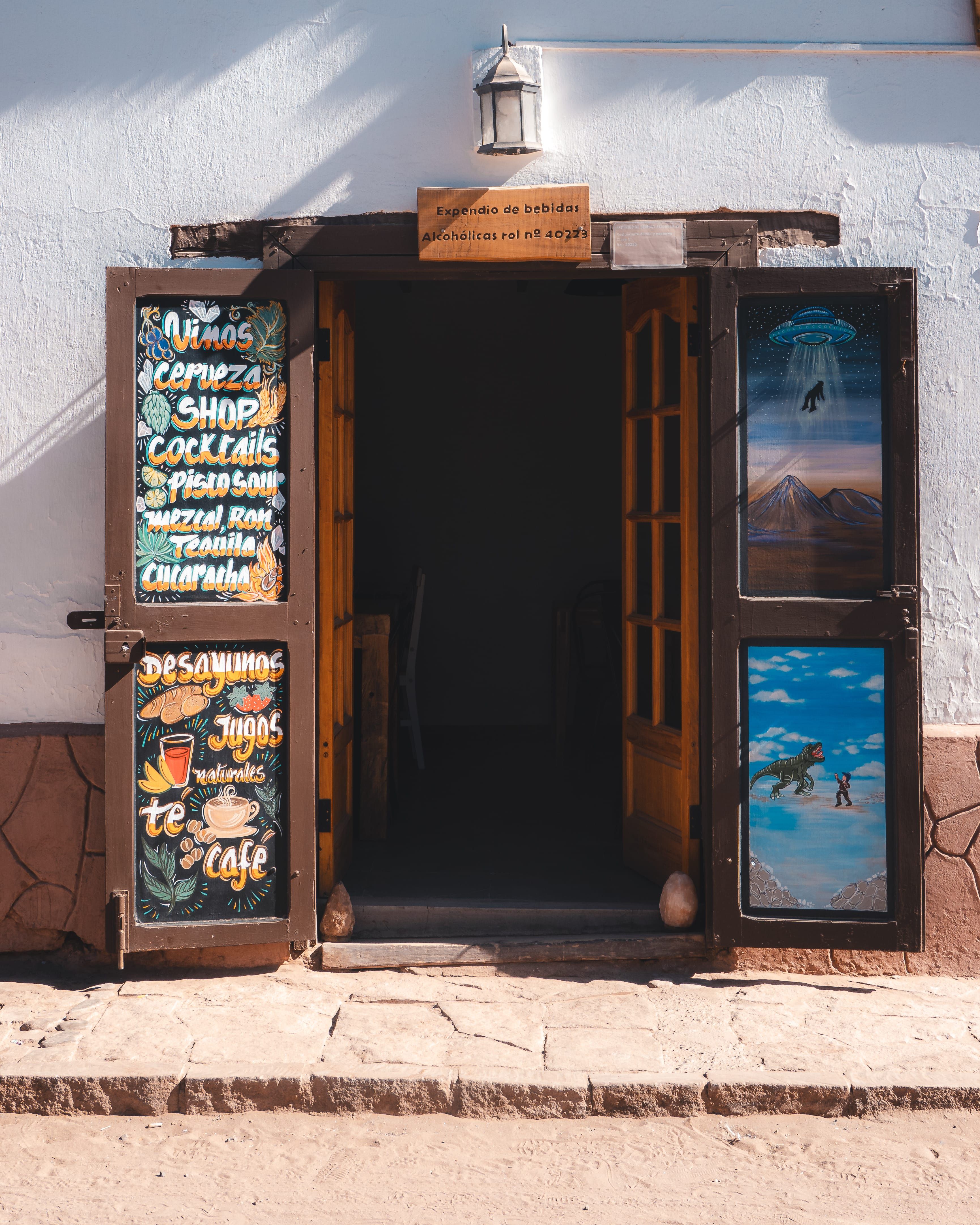 Charming Café Entrance with Artistic Painted Doors · Free Stock Photo