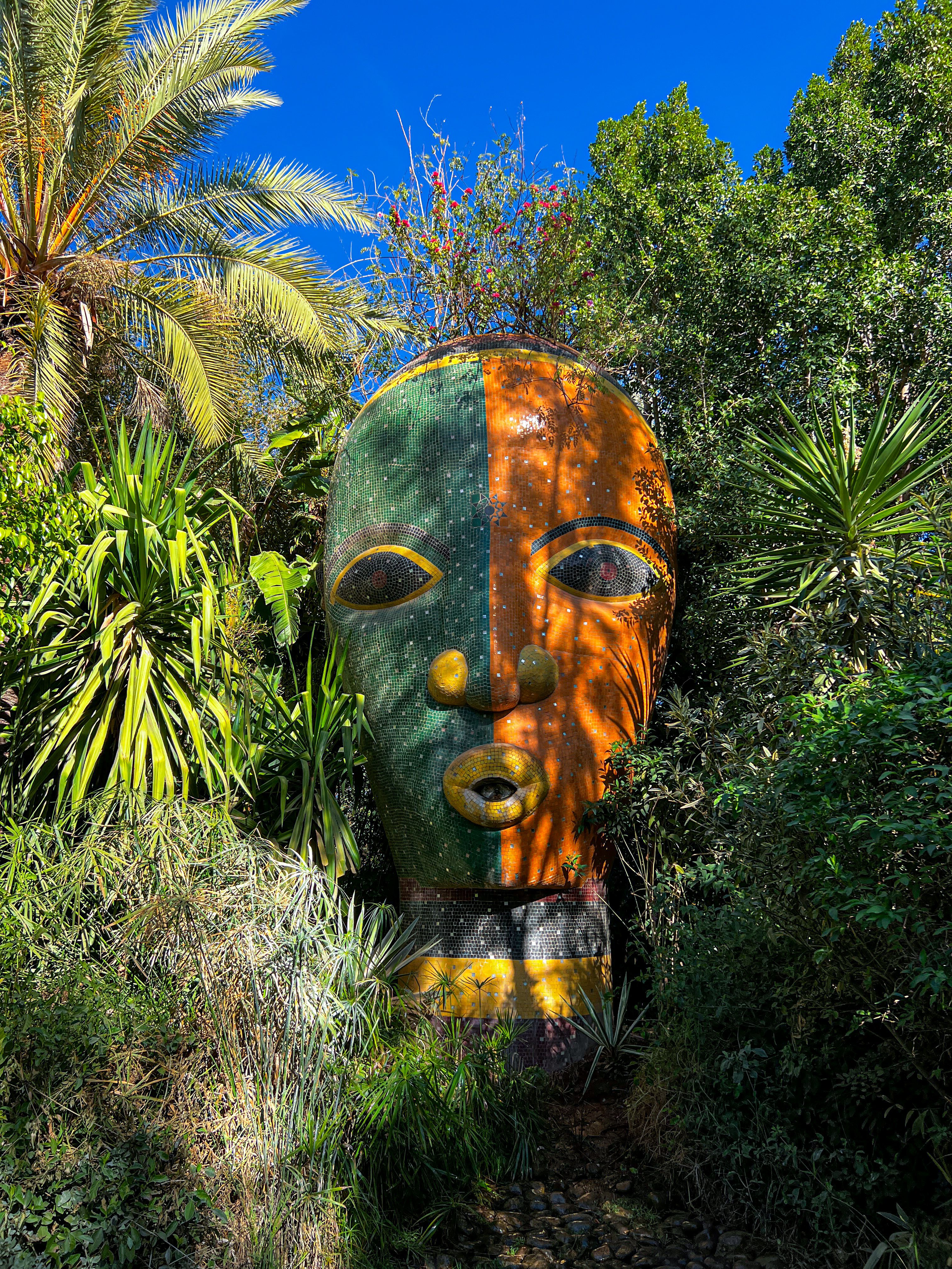 Vibrant African Mask in Lush Moroccan Garden · Free Stock Photo