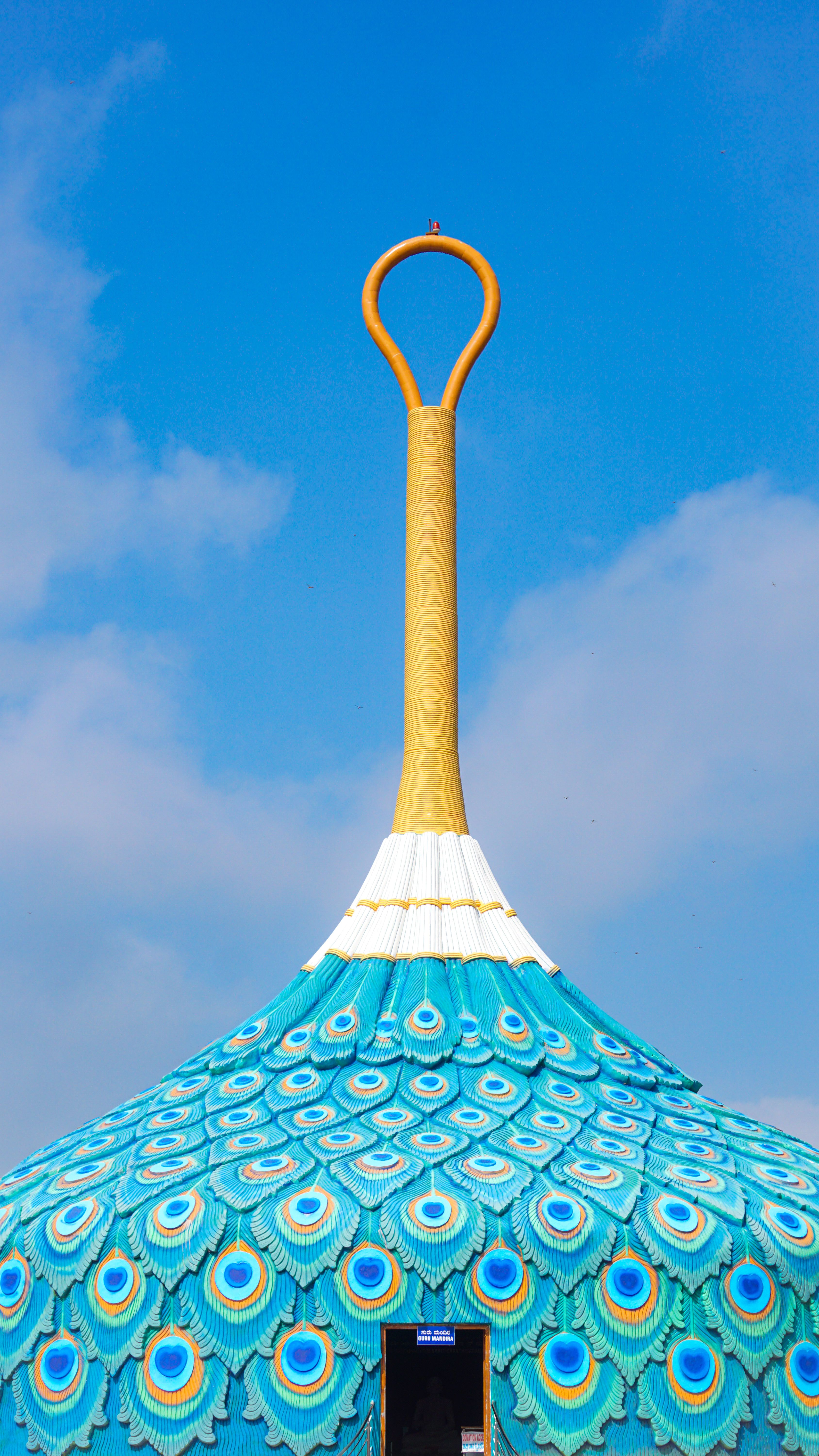 Colorful Peacock-Themed Roof Against Blue Sky · Free Stock Photo