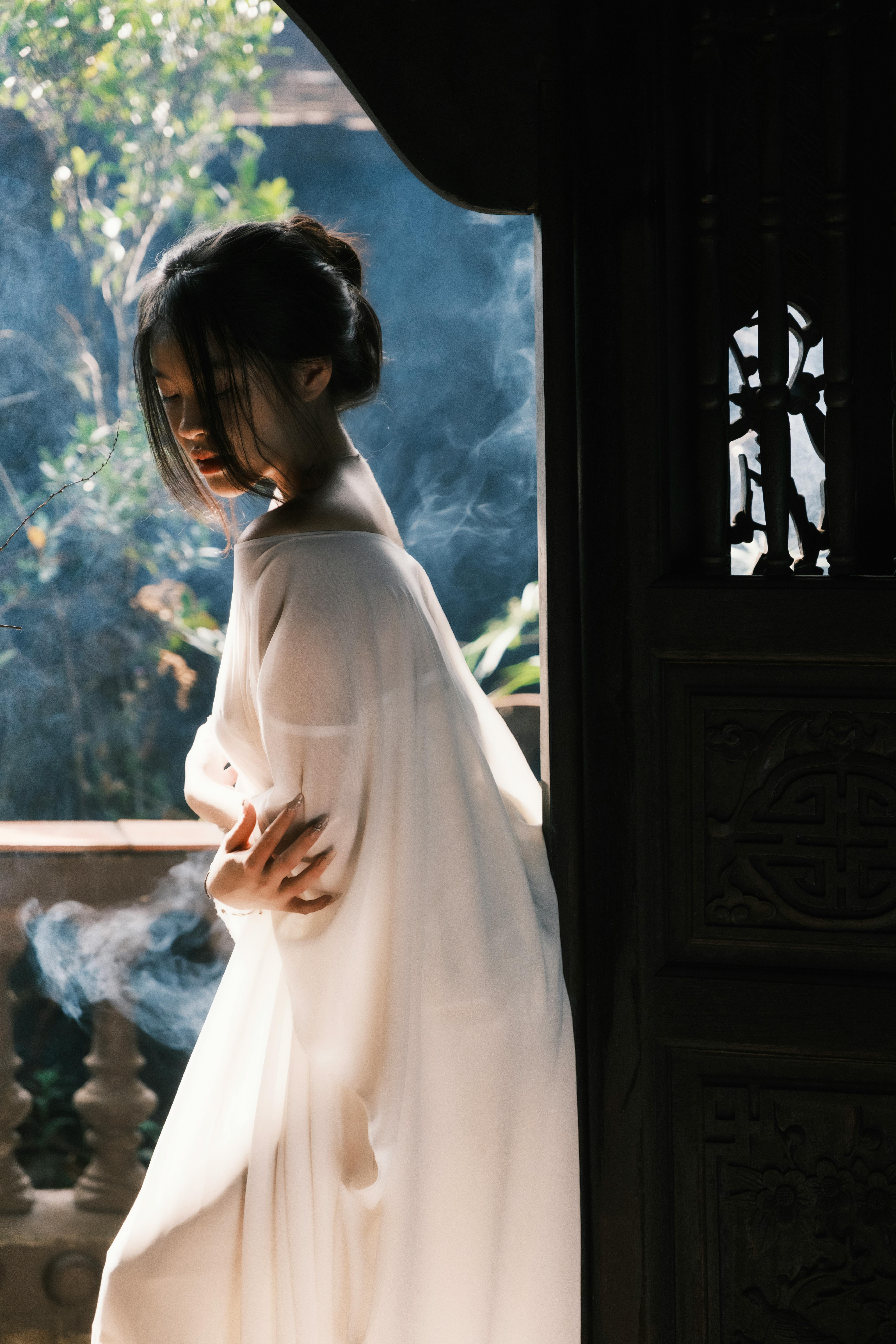 Elegant Woman in Flowing Robe with Indoor Light · Free Stock Photo