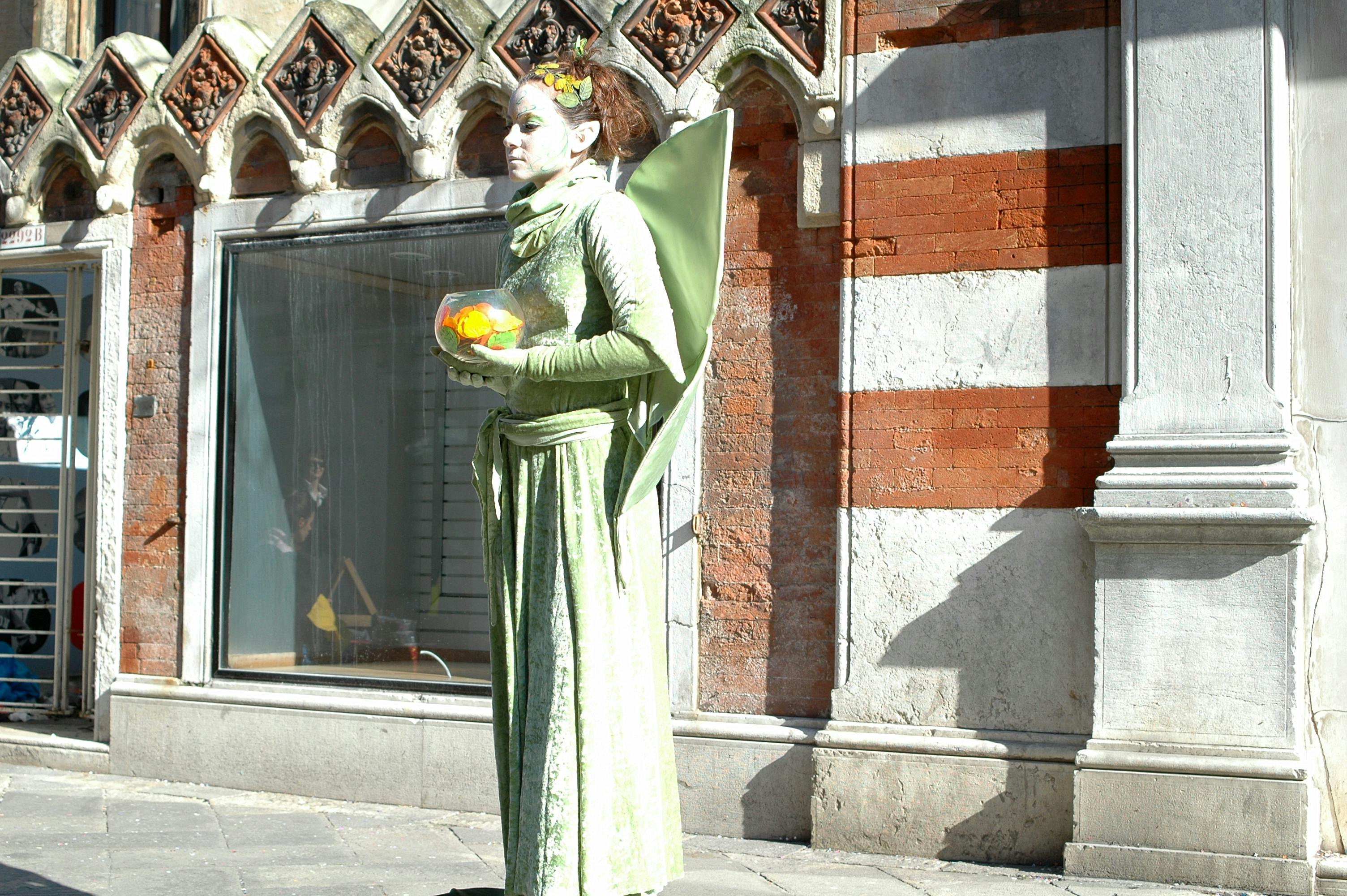 Street Performer in Fantasy Costume Holding Globe · Free Stock Photo