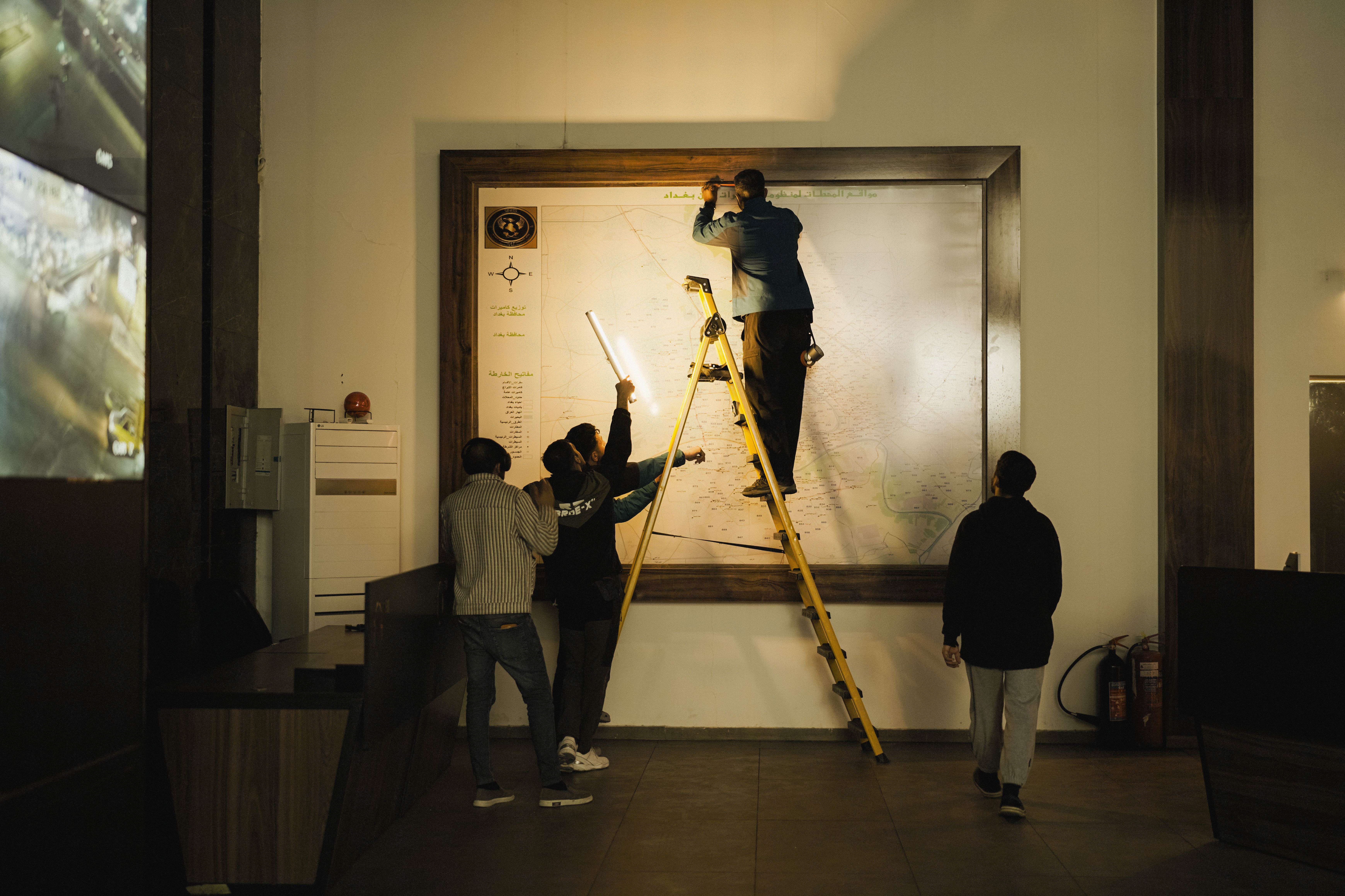 Team Working on a Map Installation Indoors · Free Stock Photo