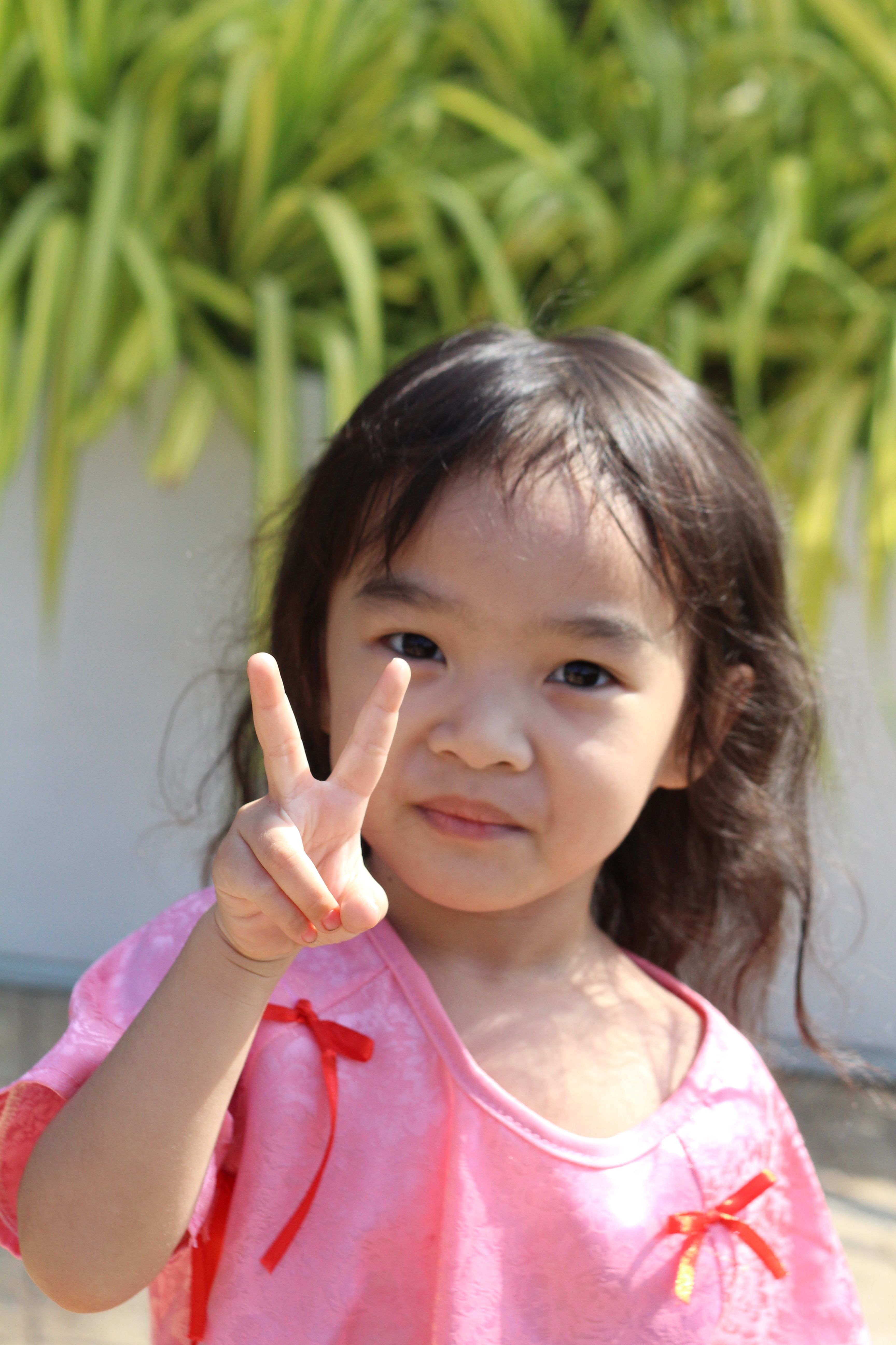 Happy Child Celebrating Outdoors with Peace Sign · Free Stock Photo