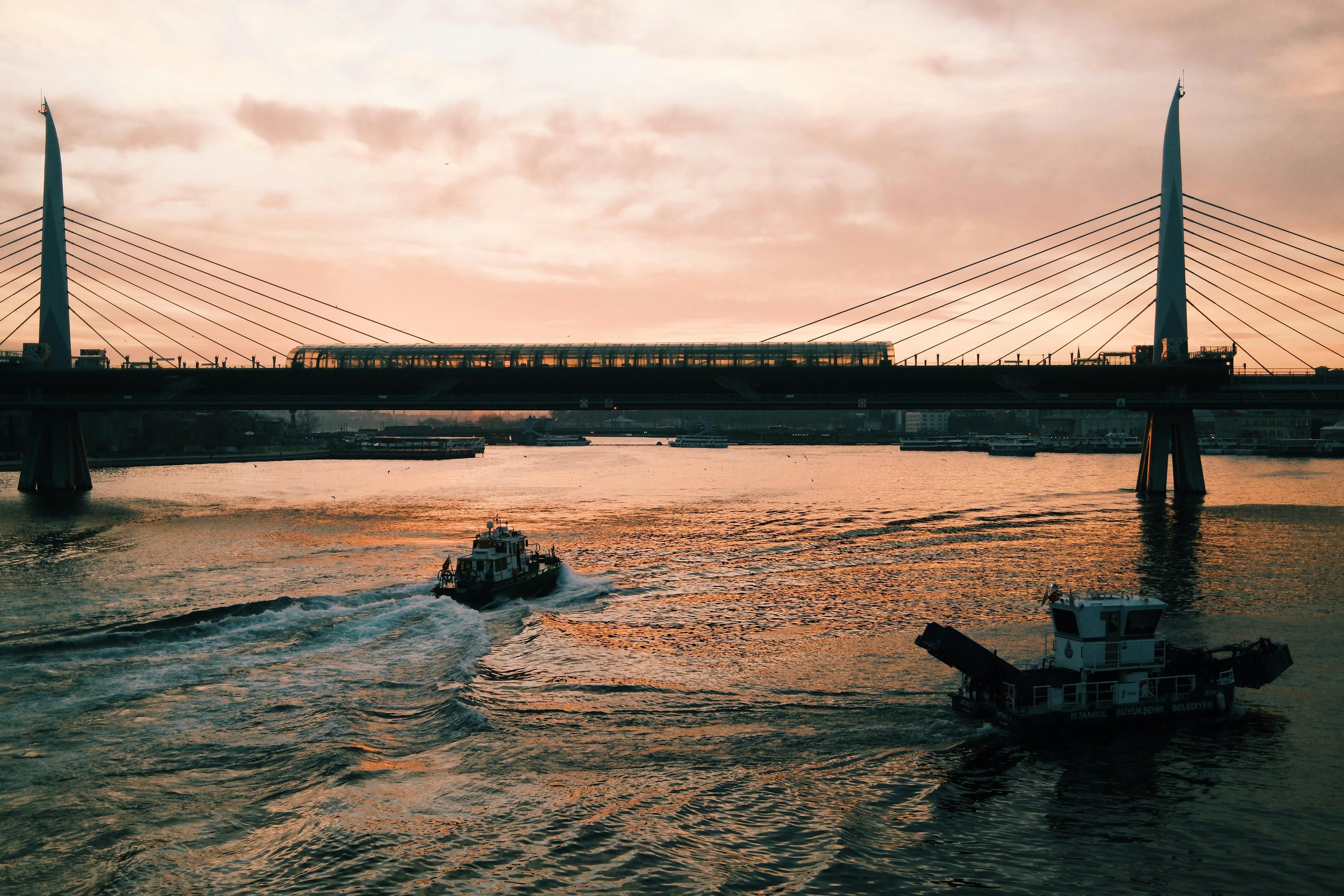 Sunset Over Modern Suspension Bridge with Boats · Free Stock Photo