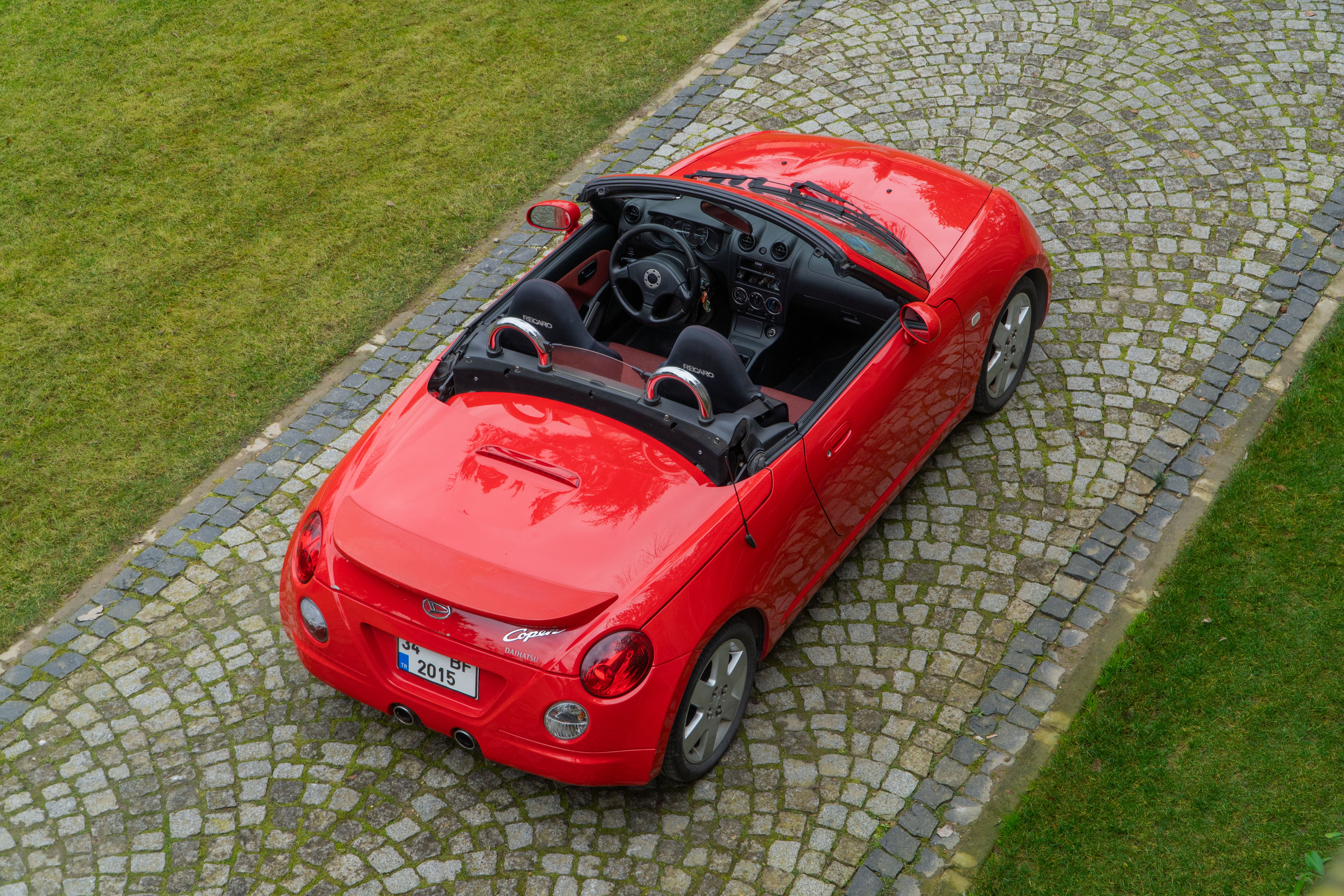 Automóvil Convertible Rojo Estacionado En Un Camino Adoquinado · Foto ...