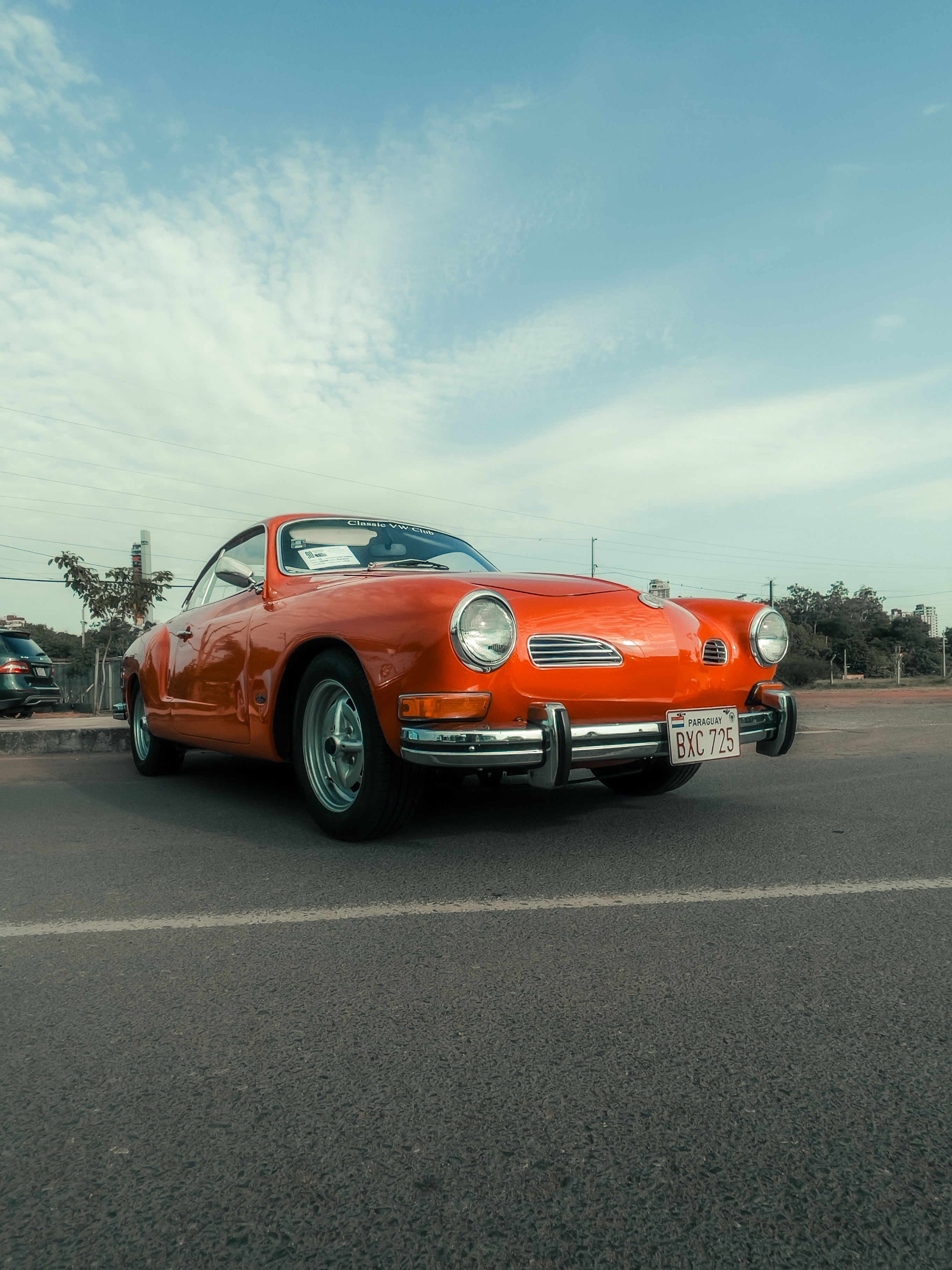 Orange Vintage Car on Open Road Under Blue Sky · Free Stock Photo