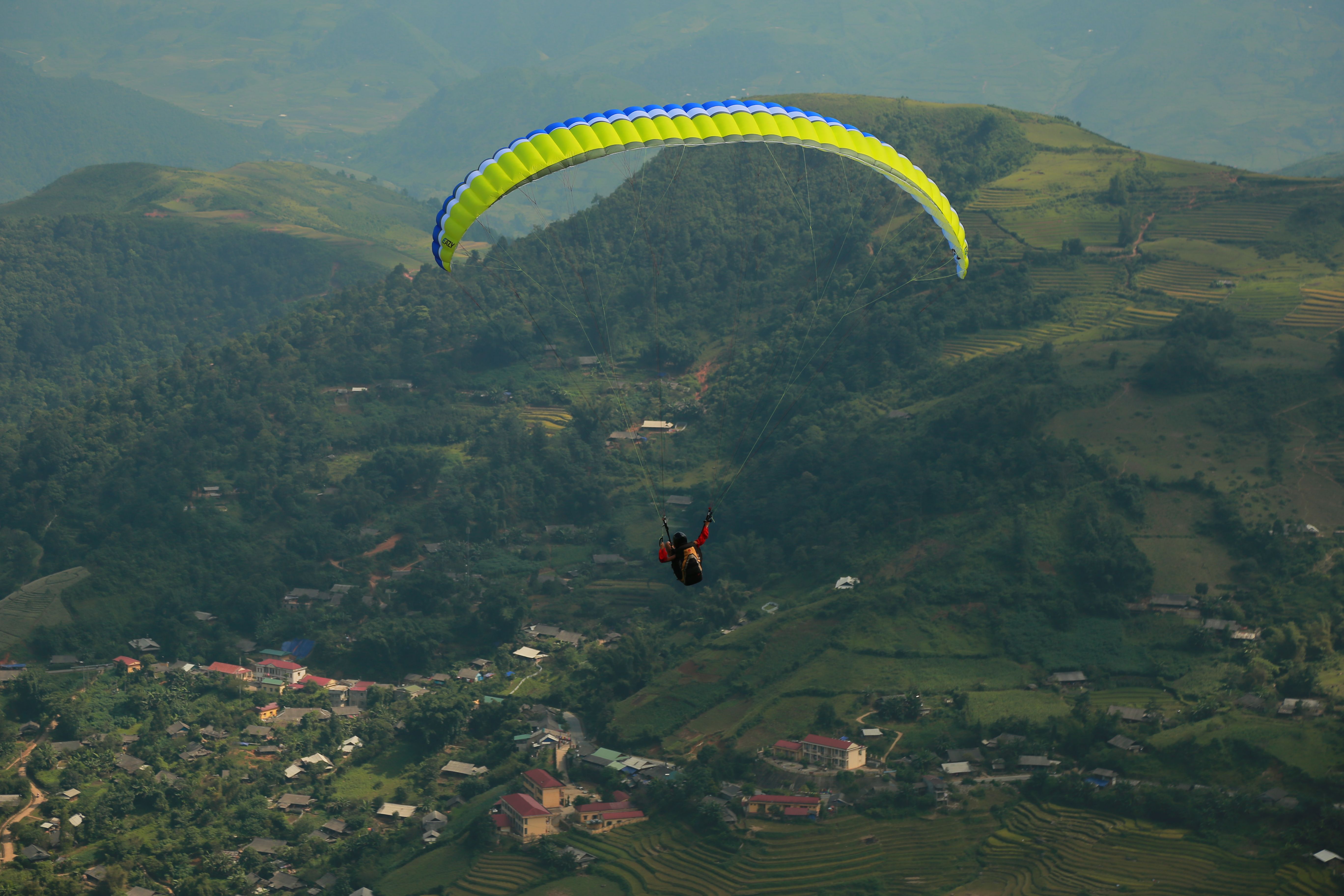 Aerial Paragliding Adventure Over Verdant Hills · Free Stock Photo