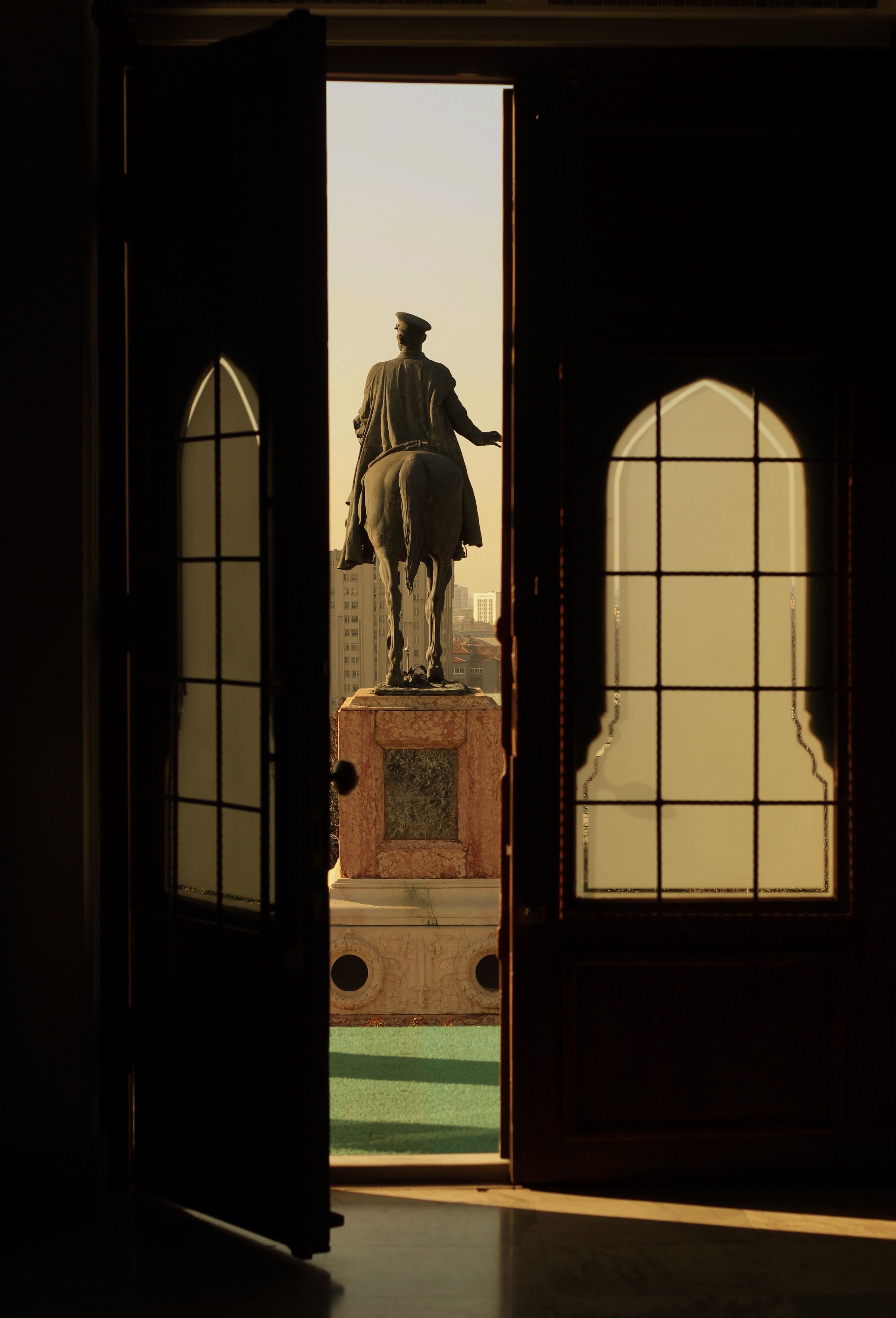 Silhouette of an Equestrian Statue through Open Doors · Free Stock Photo