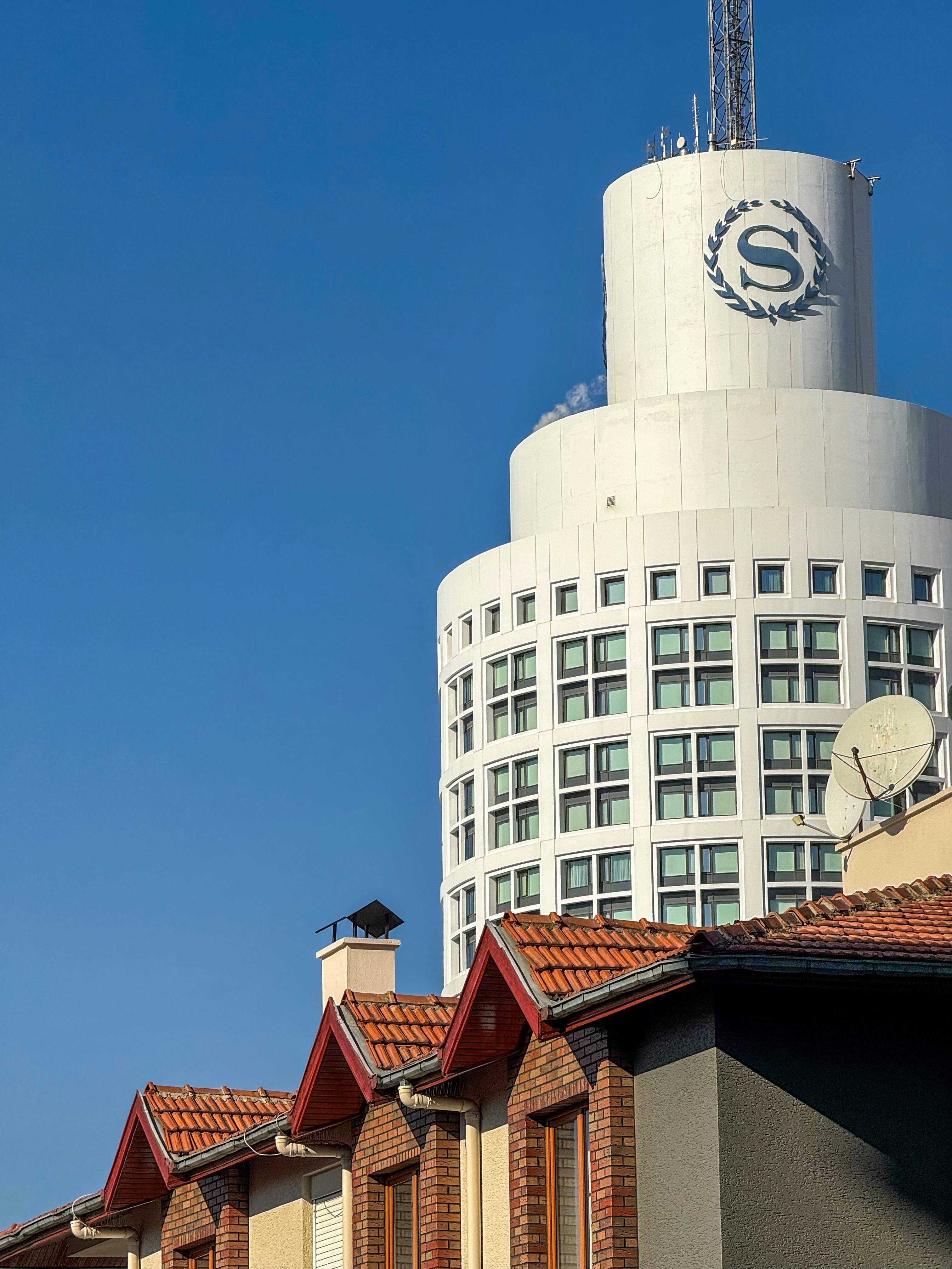 Modern Hotel Tower and Traditional Rooftops · Free Stock Photo
