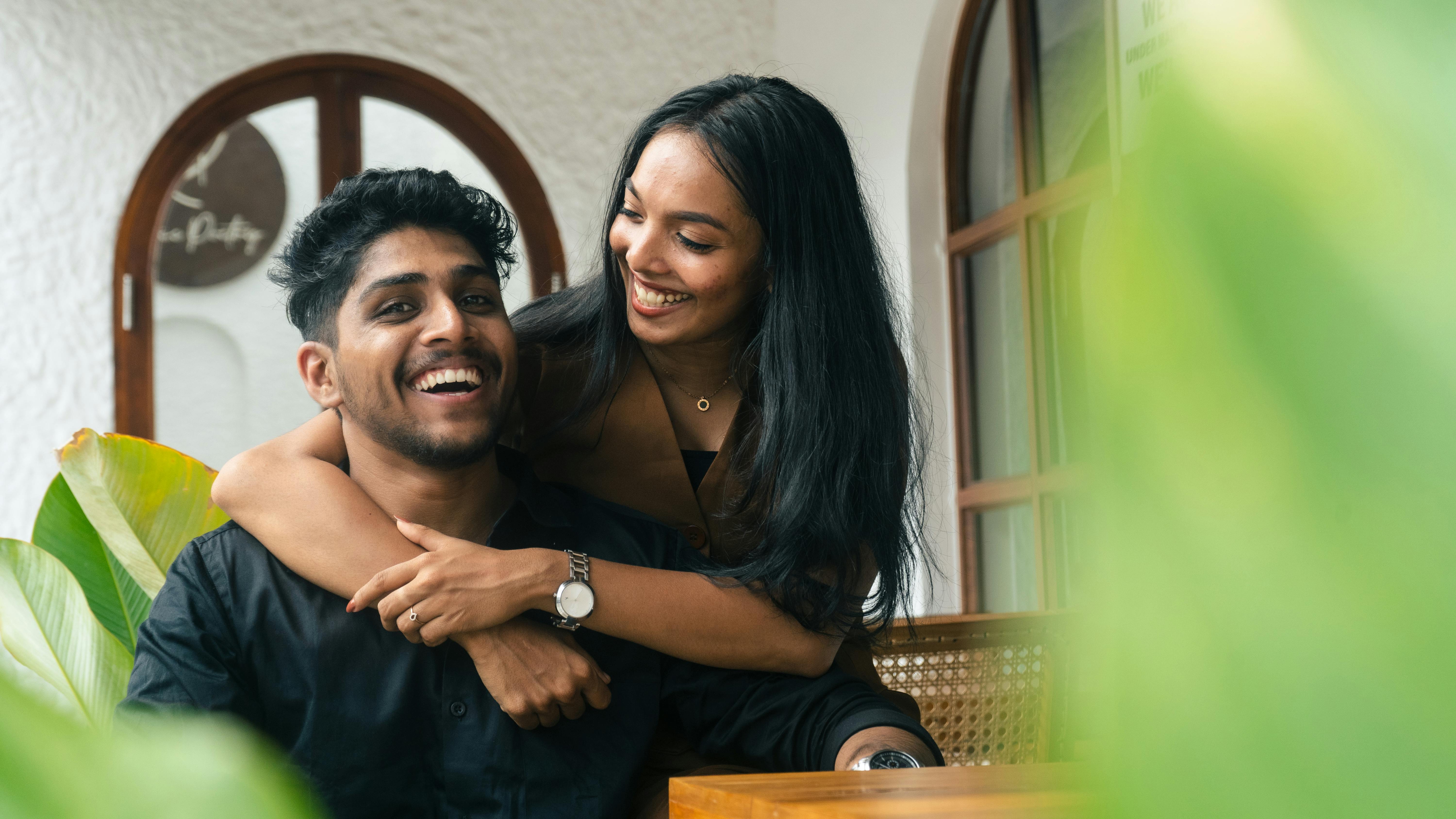 Joyful Couple Embracing in a Cozy Cafe Setting · Free Stock Photo