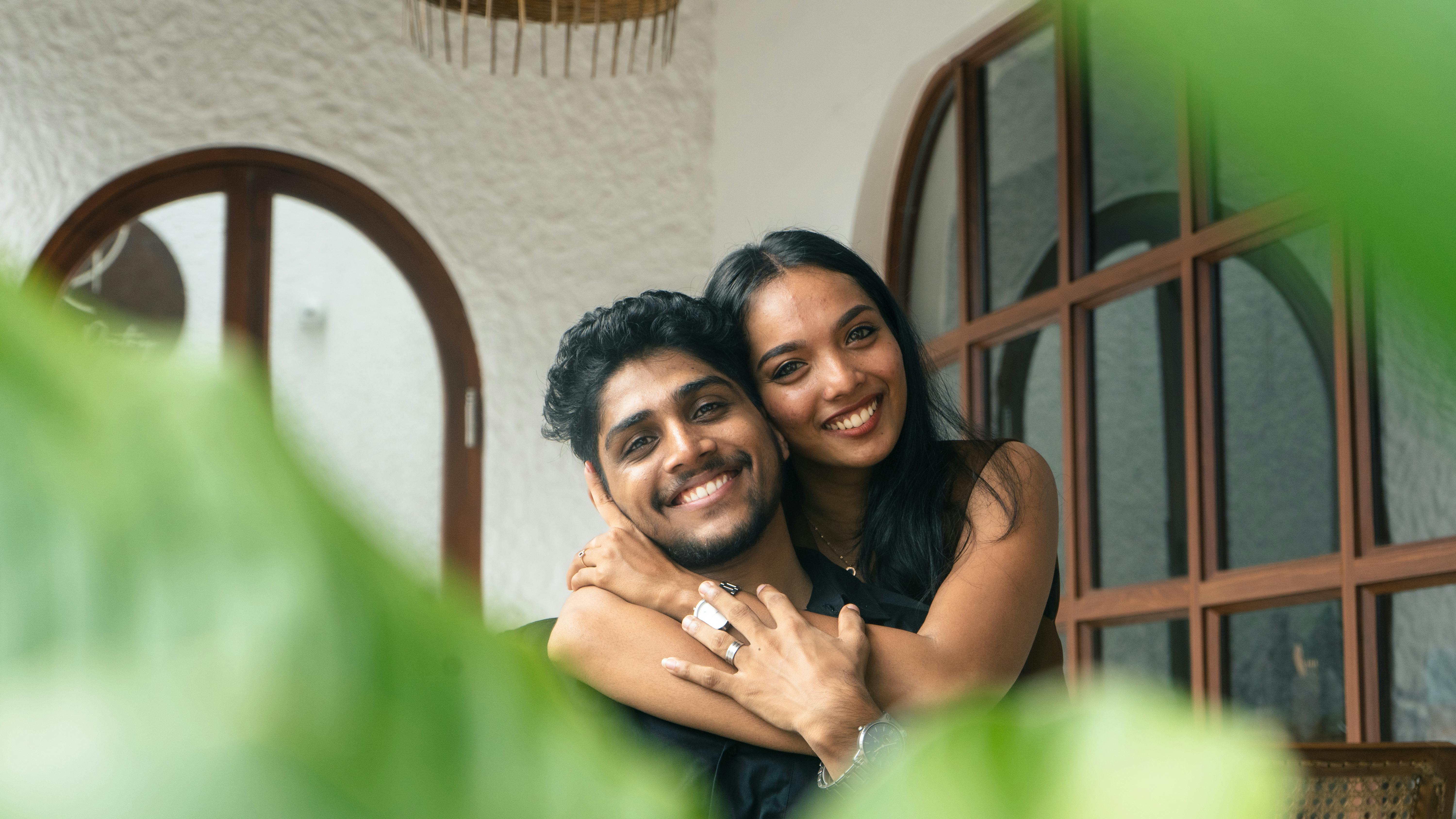 Happy Couple Embracing in a Cozy Café Setting · Free Stock Photo