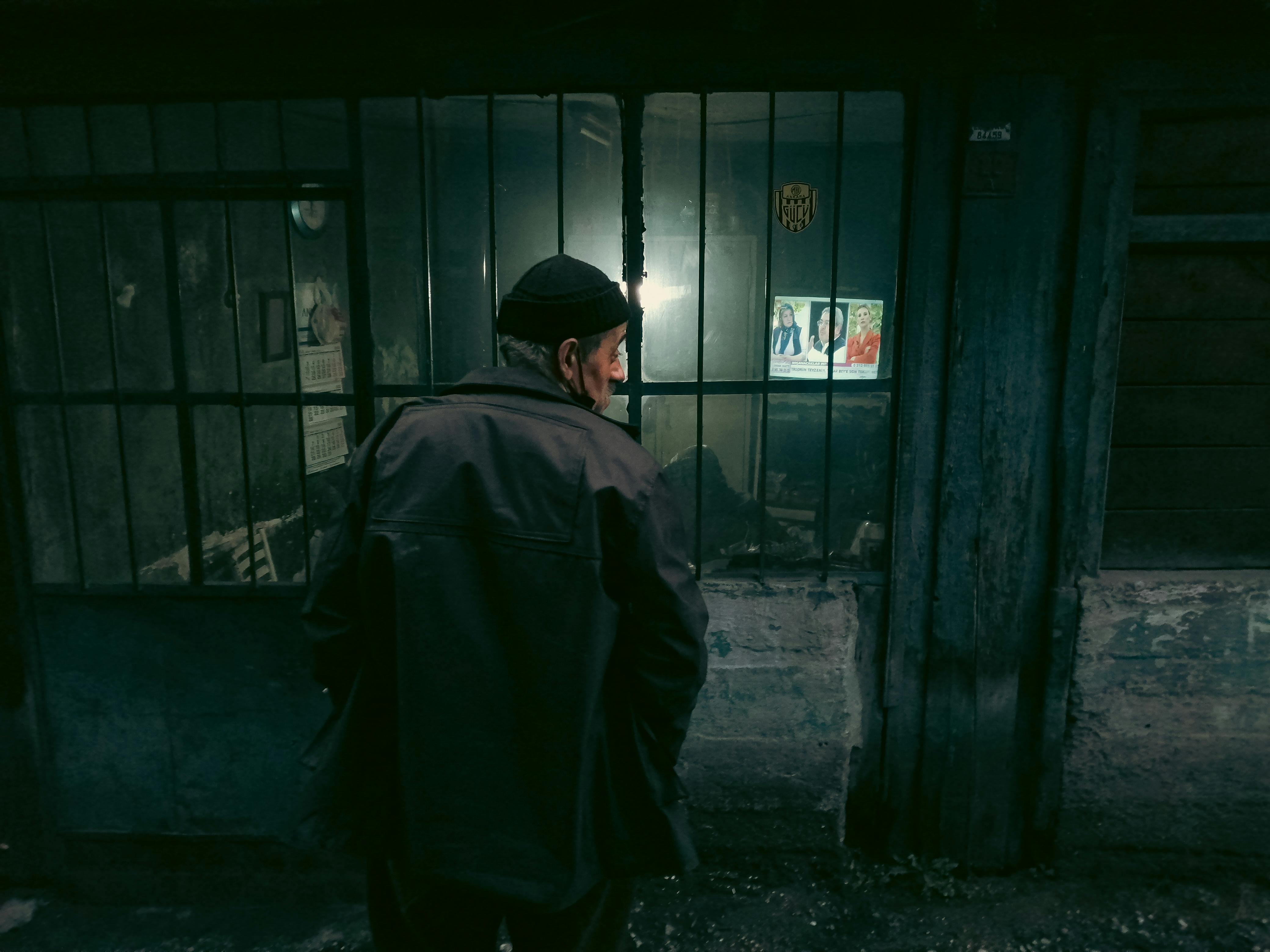 Elderly Man in Front of Dimly Lit Windowed Shop · Free Stock Photo