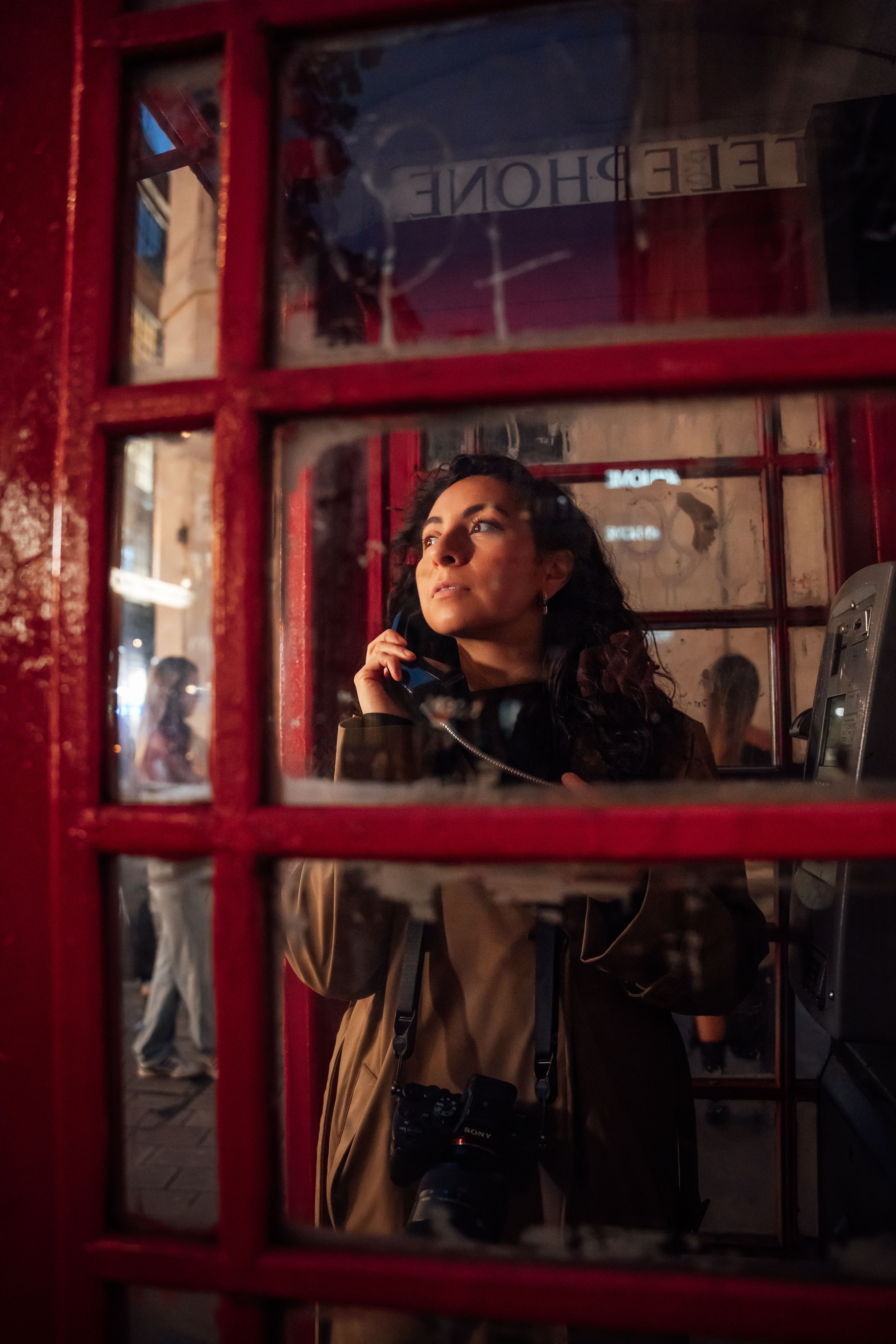 Person Inside Iconic London Phone Booth at Night · Free Stock Photo