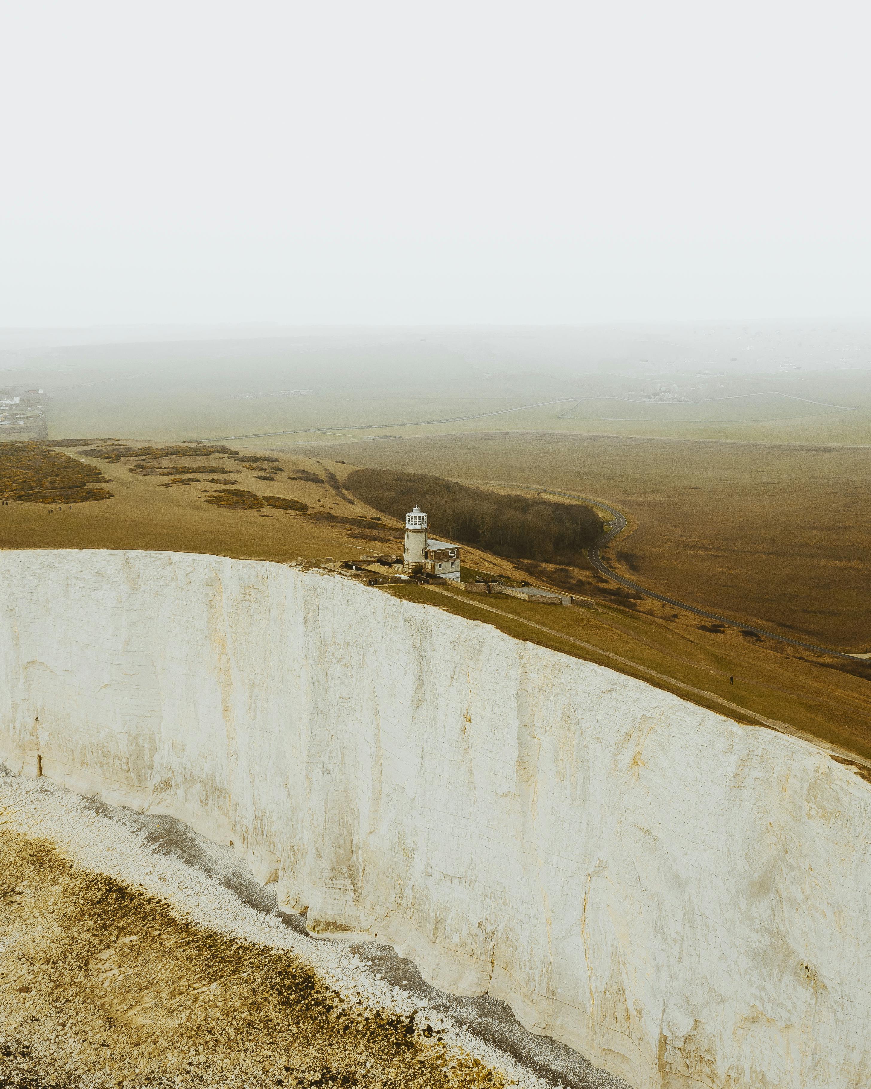 White Concrete Lighthouse On The Edge Of A Mountain Cliff · Free Stock ...