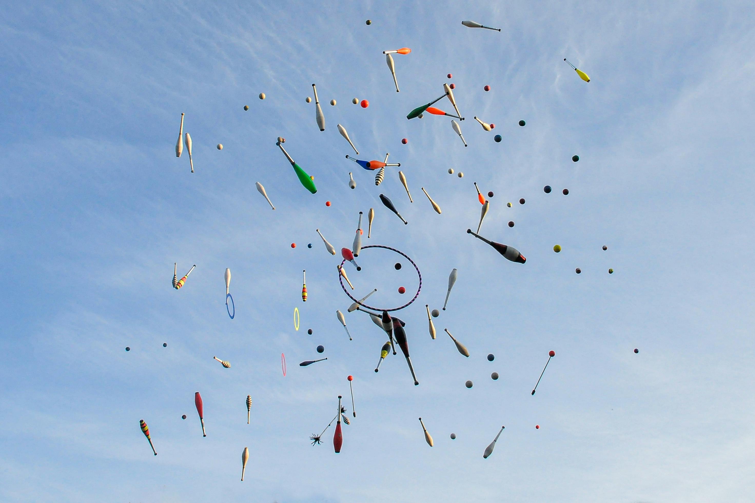 Dynamic Juggling Props Against a Clear Blue Sky · Free Stock Photo